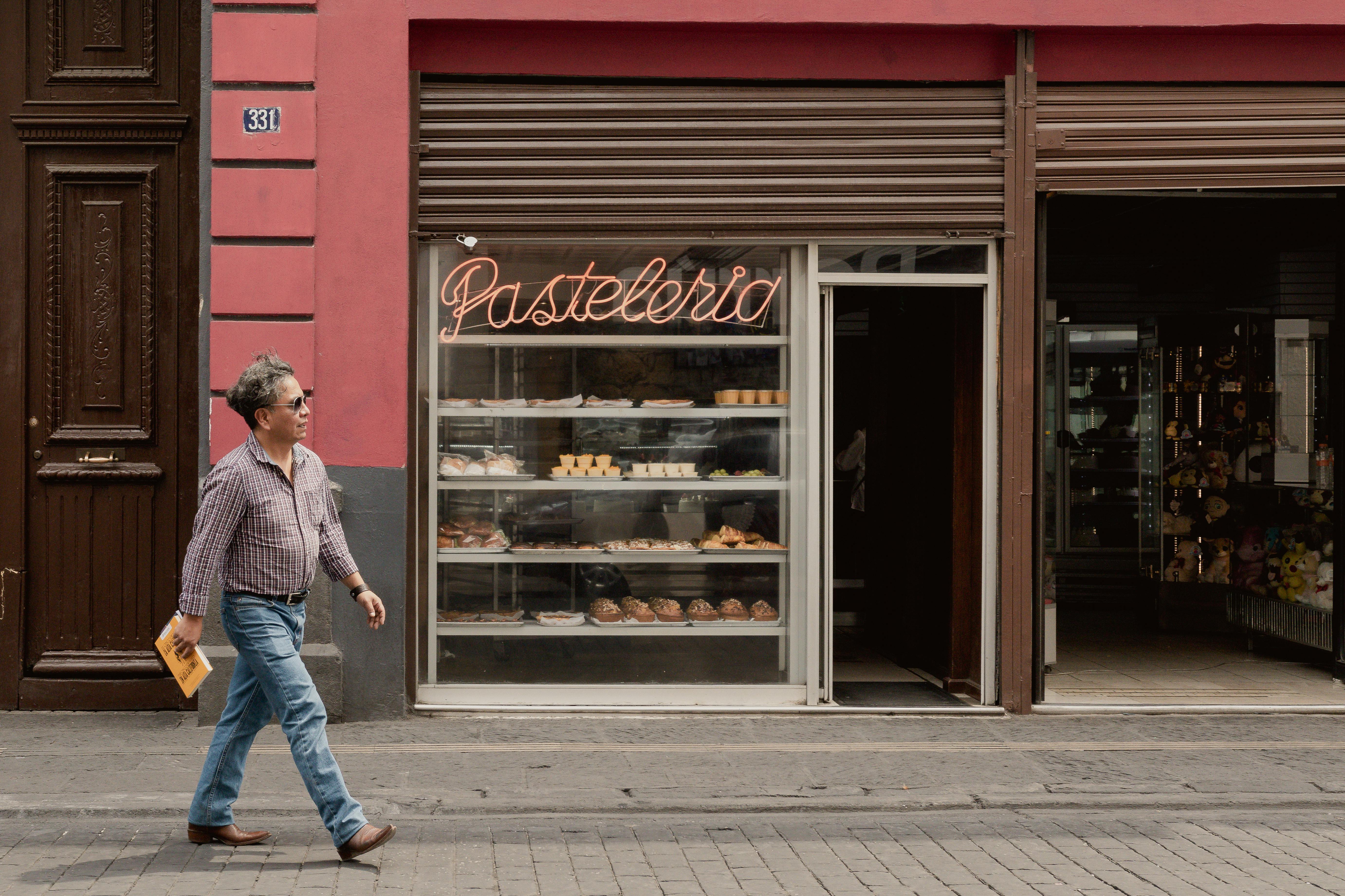 Man Walking near Confectionery · Free Stock Photo