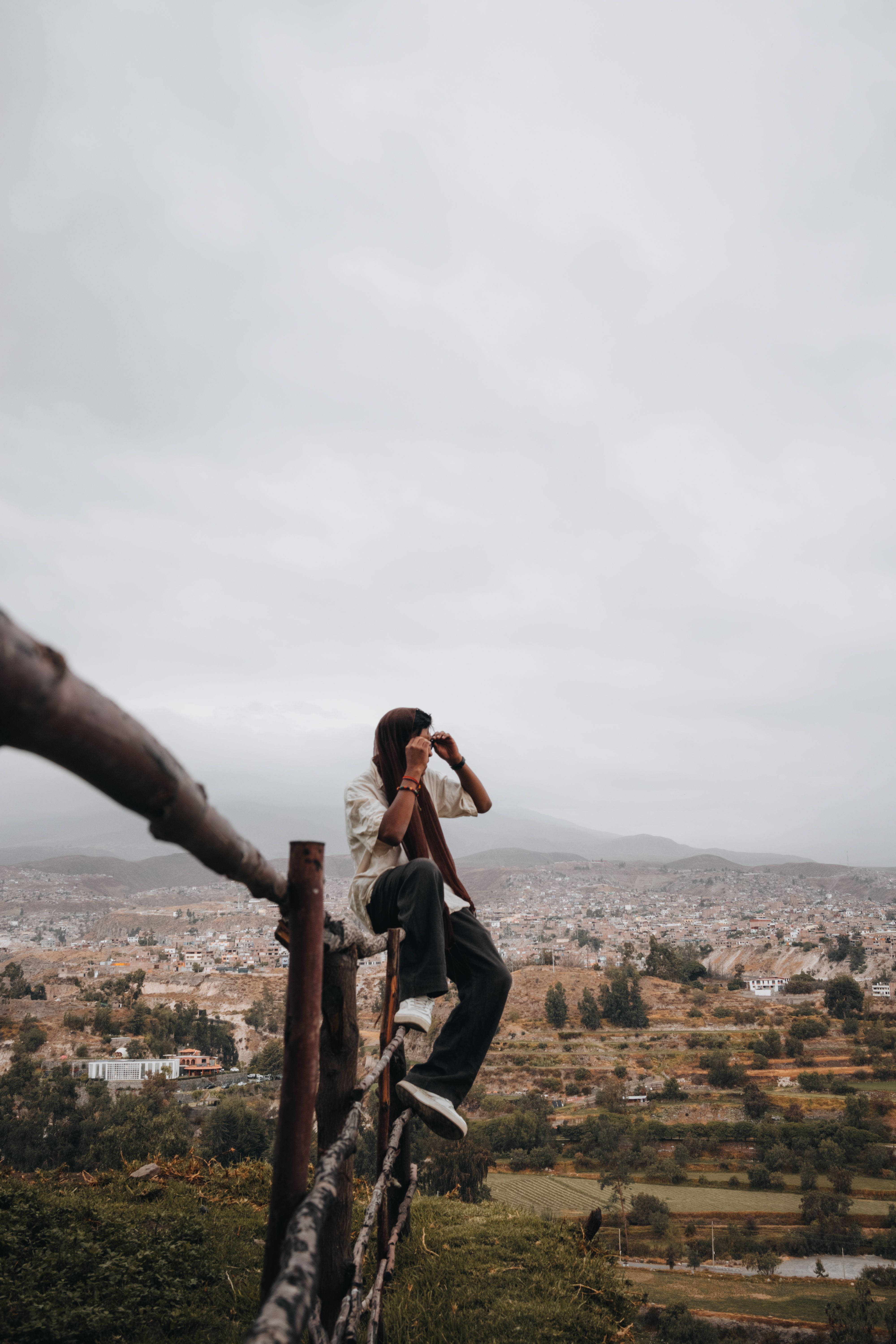 Person Sitting on Wooden Fence in Countryside · Free Stock Photo