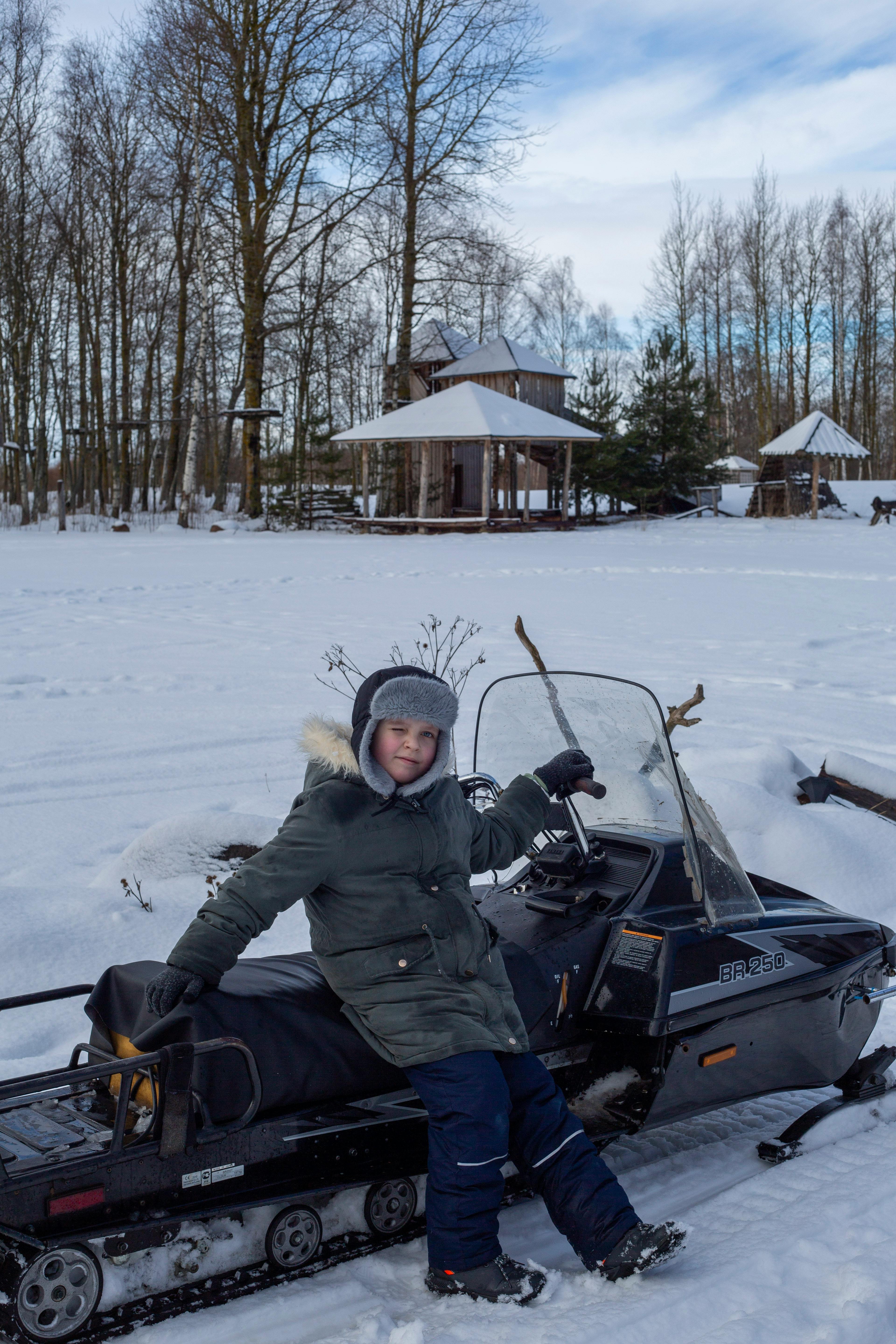 Little Boy in Coat Sitting on Snowmobile · Free Stock Photo
