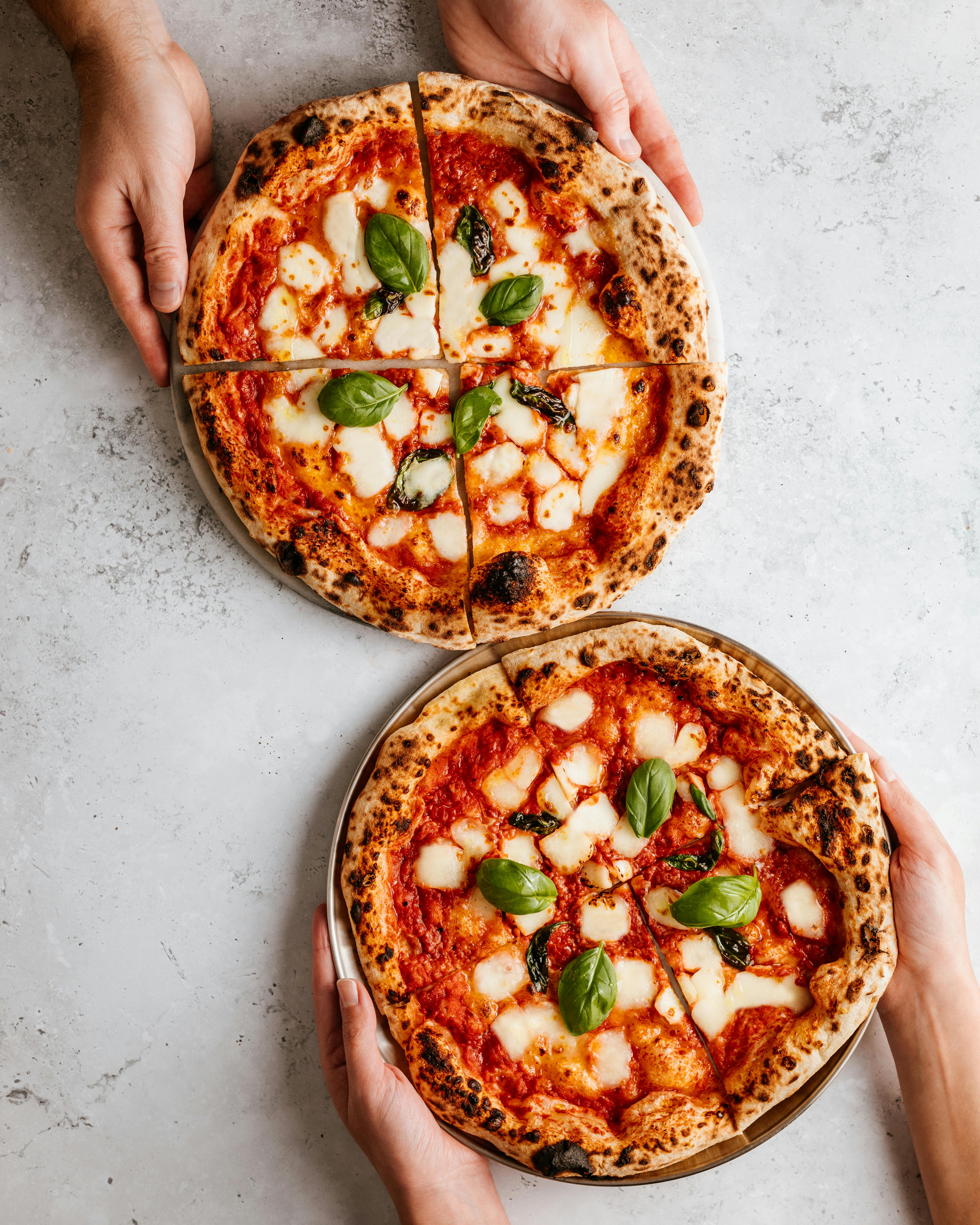 Hands Holding Pizzas · Free Stock Photo