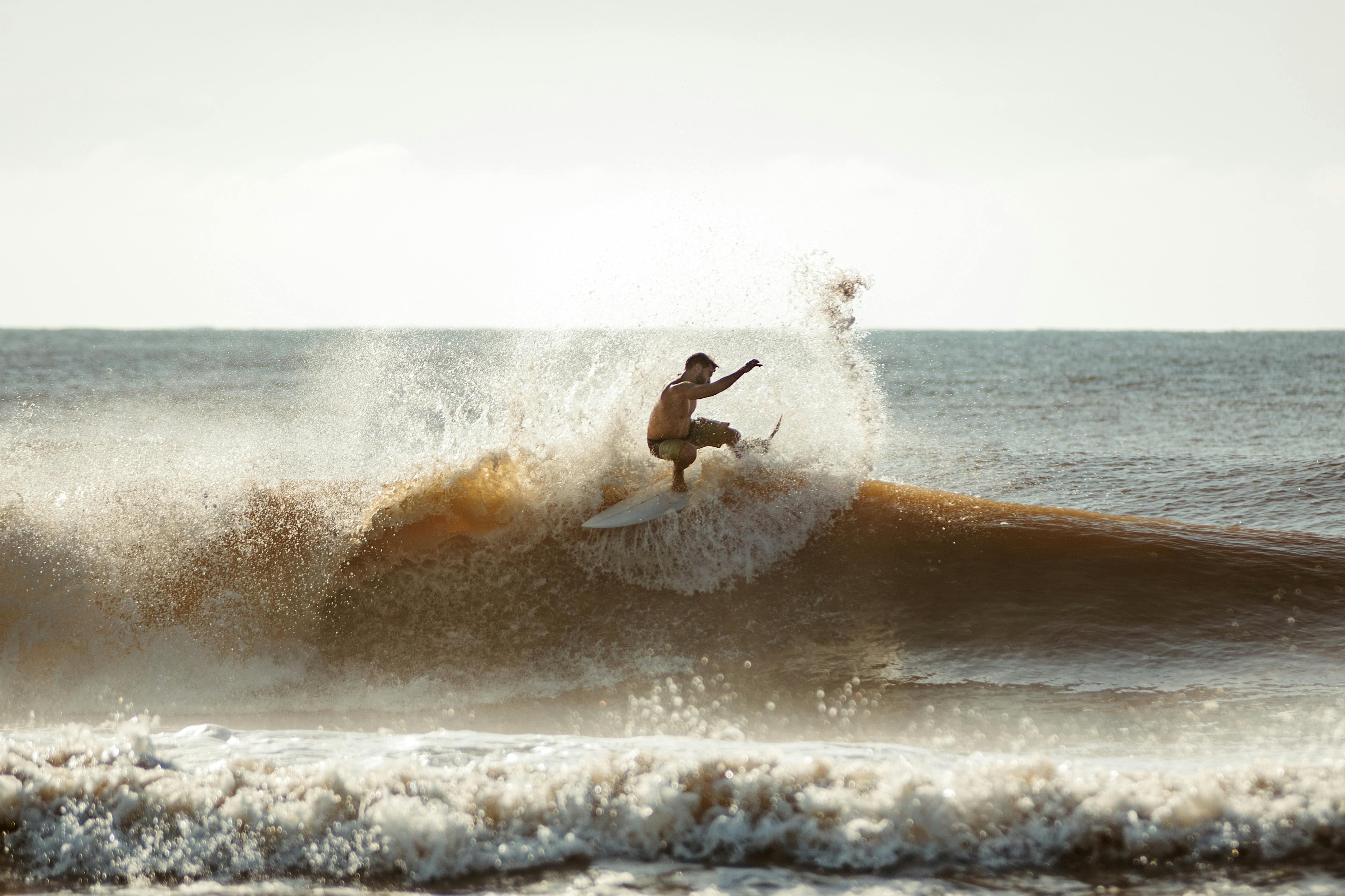 Man Surfing atop Wave under Clear Sky · Free Stock Photo
