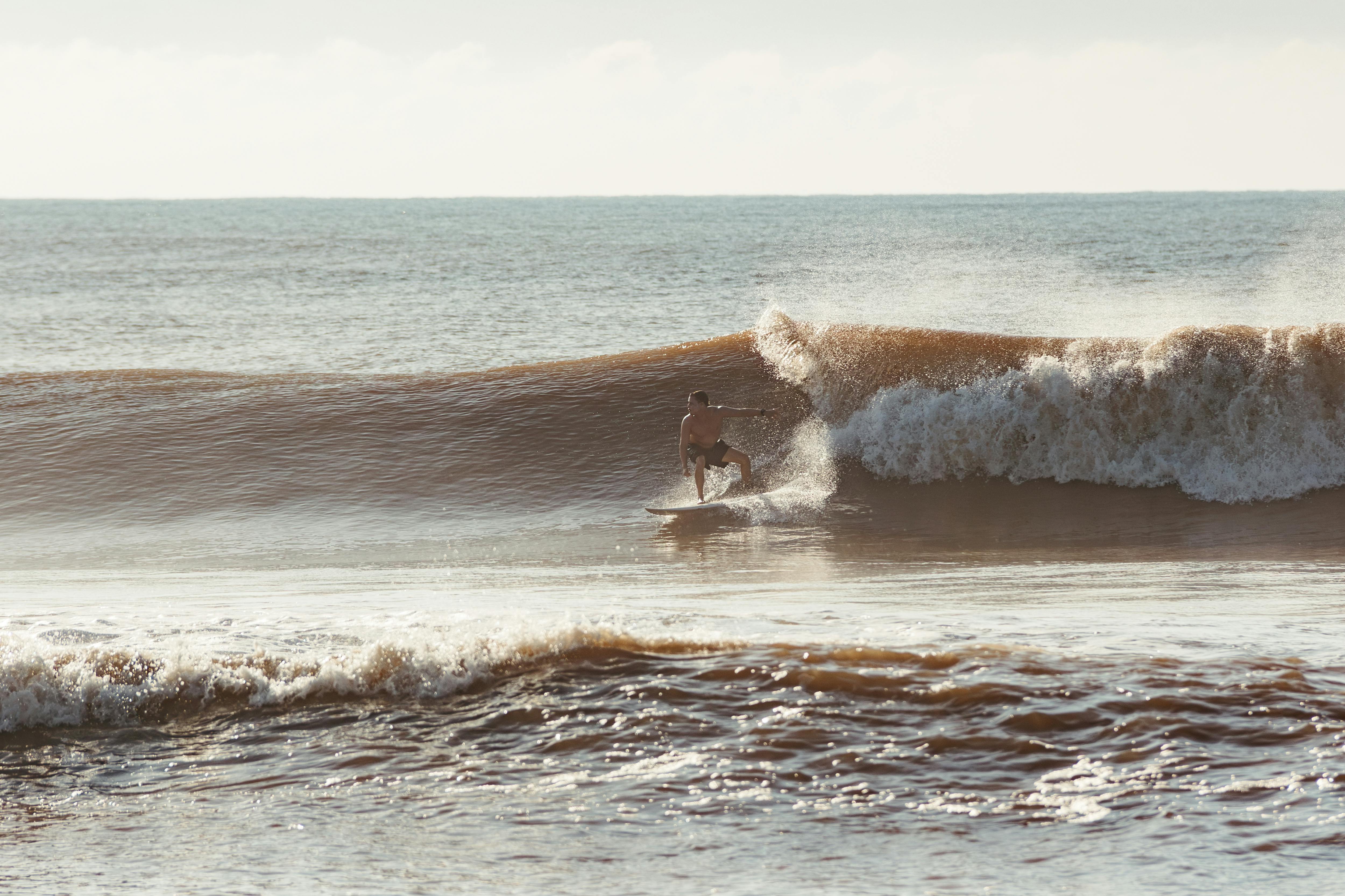 Man Surfing through Waves · Free Stock Photo