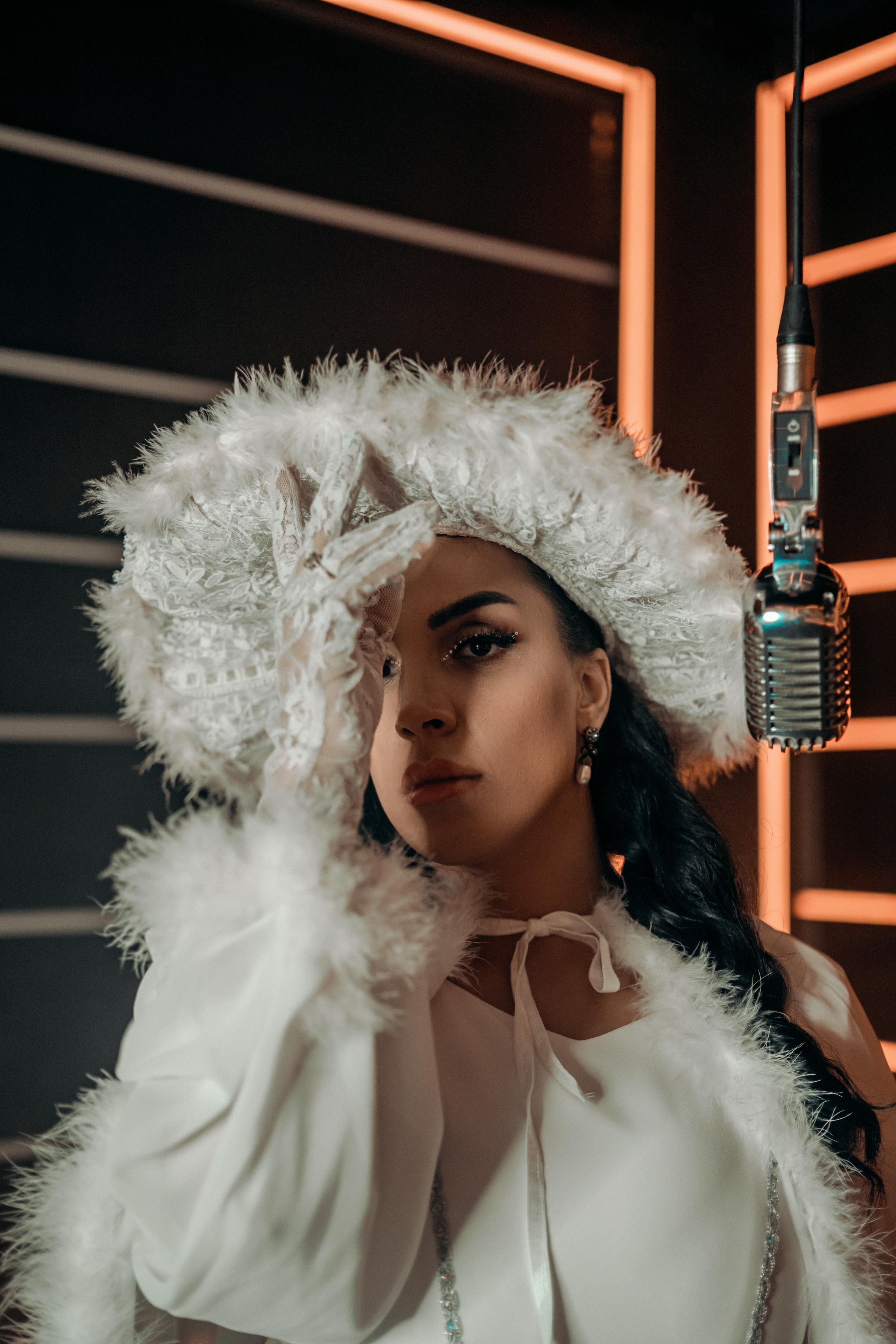 Singer in White Clothes Trimmed with Feathers · Free Stock Photo