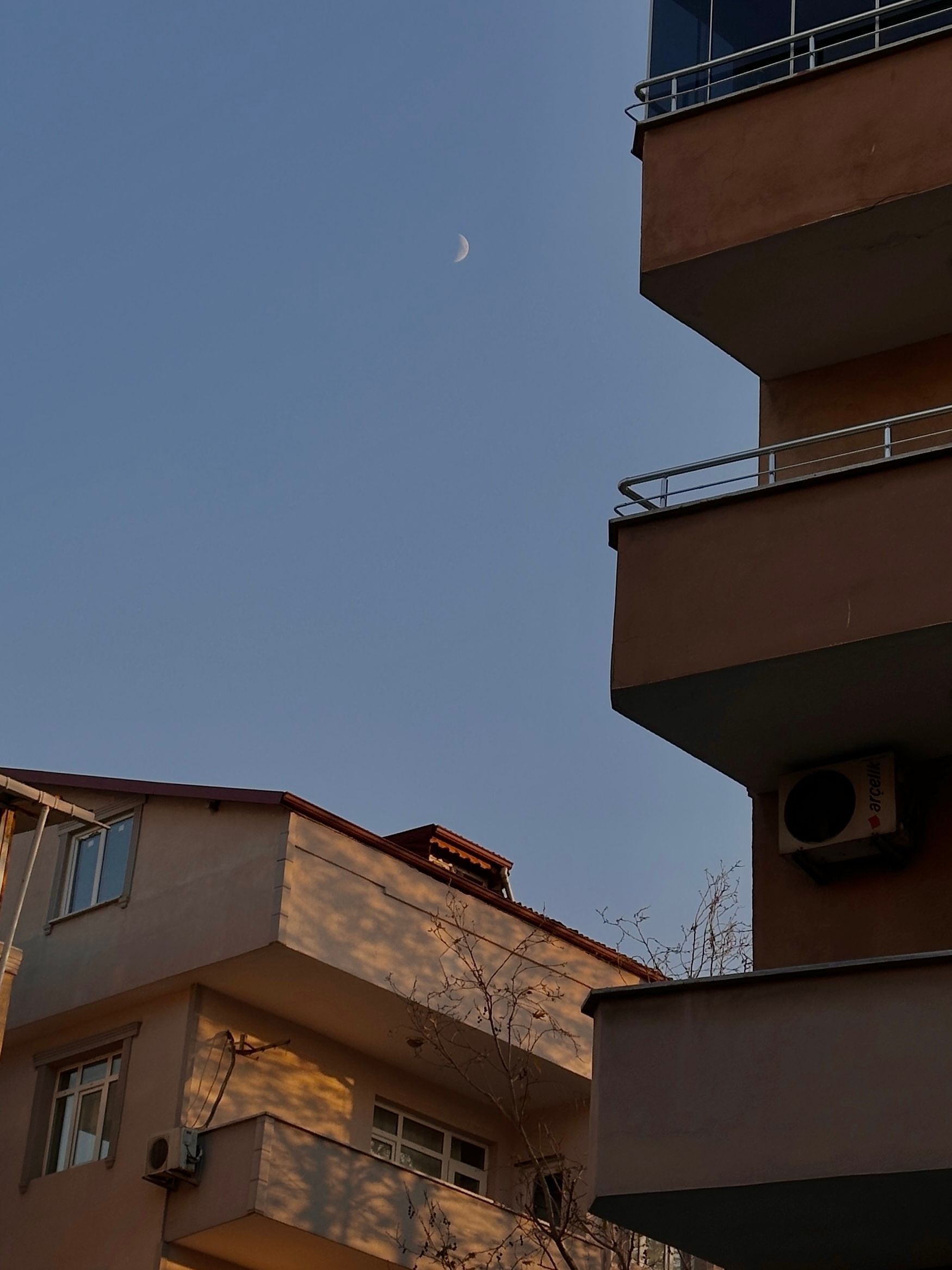 Crescent Moon behind Residential Buildings · Free Stock Photo