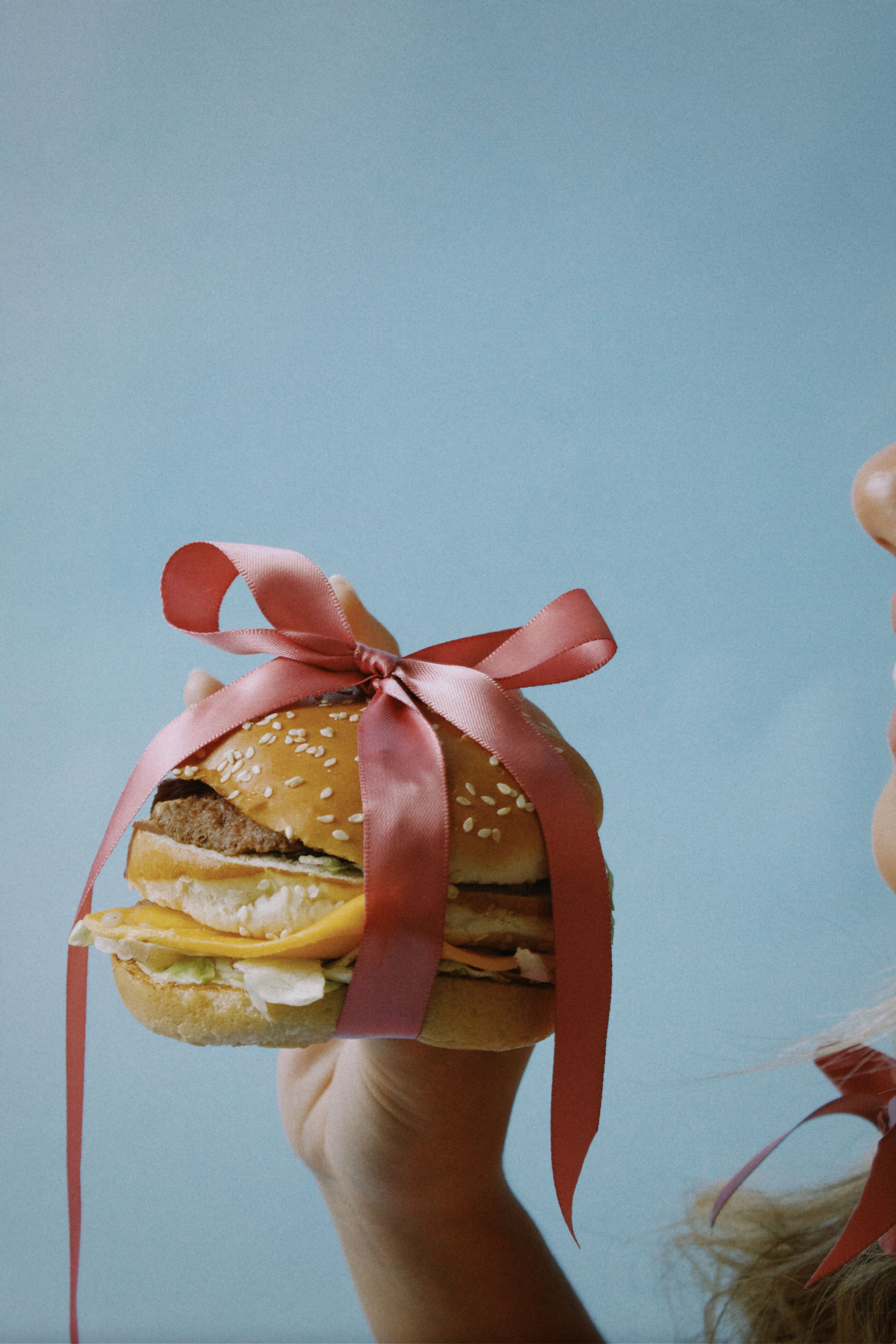 Burger with Ribbon in Hand · Free Stock Photo