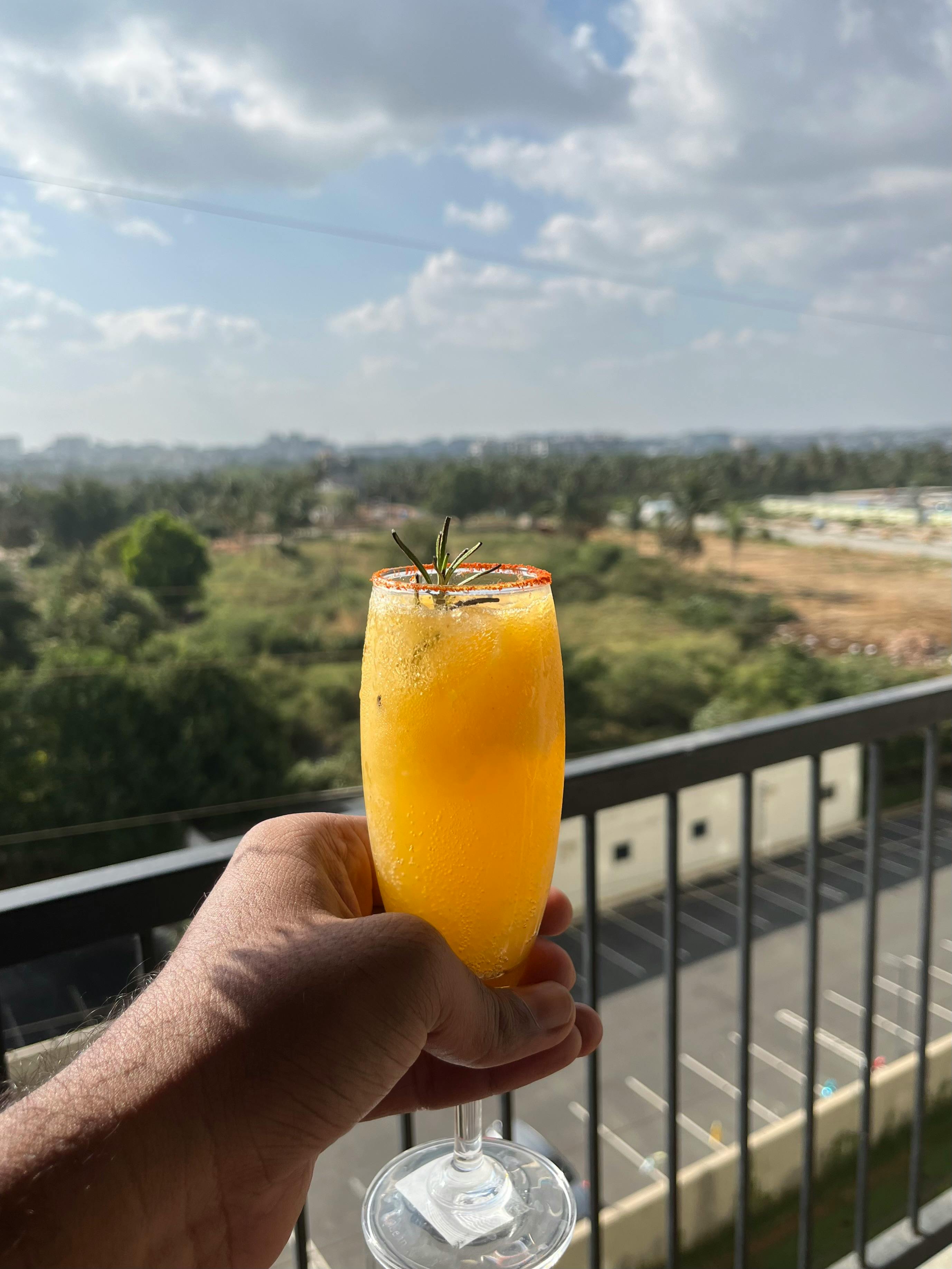Woman Holding Orange Cocktail on a Balcony · Free Stock Photo