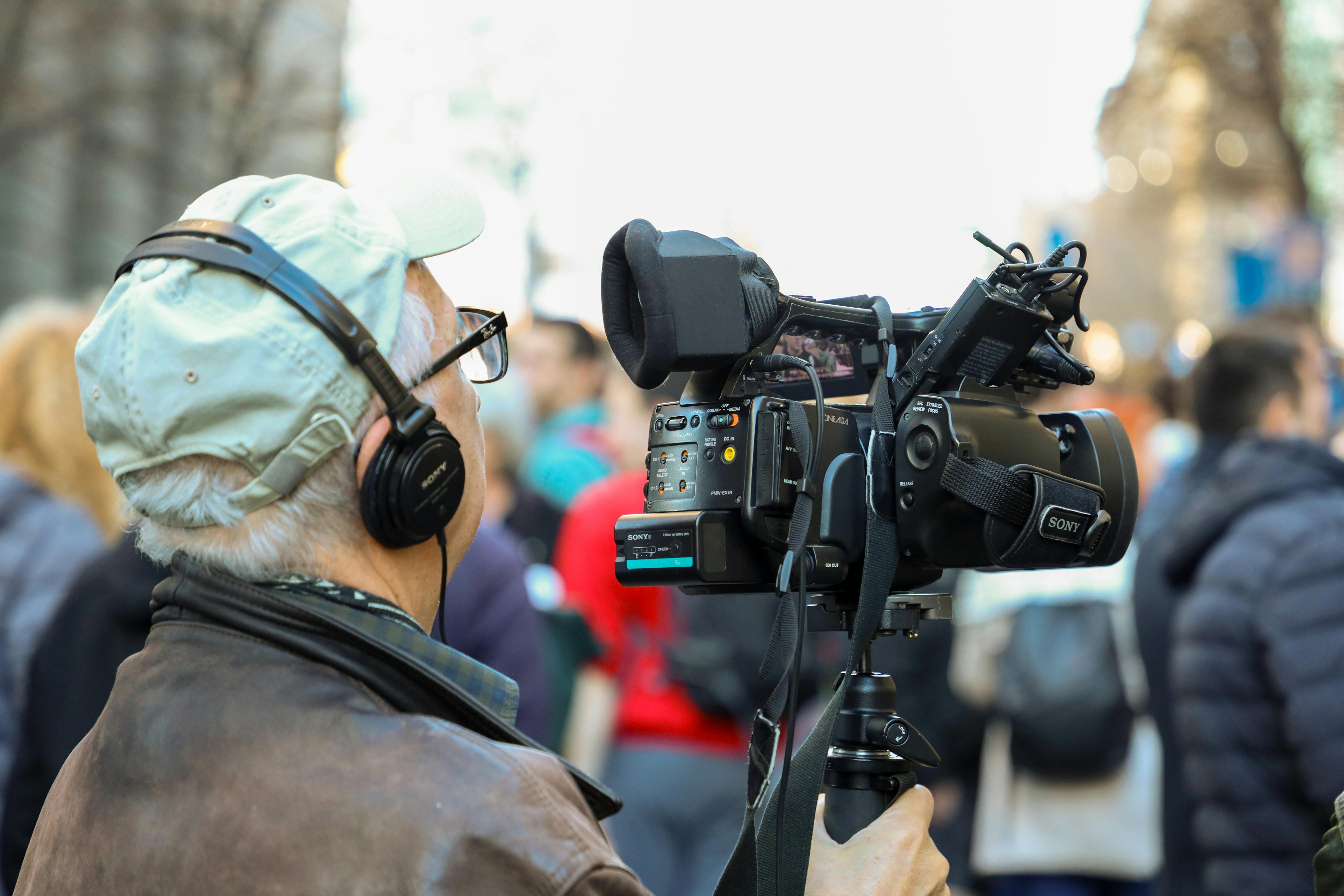 2 Camera Man Standing in a Green Metal Stage during Daytime · Free ...