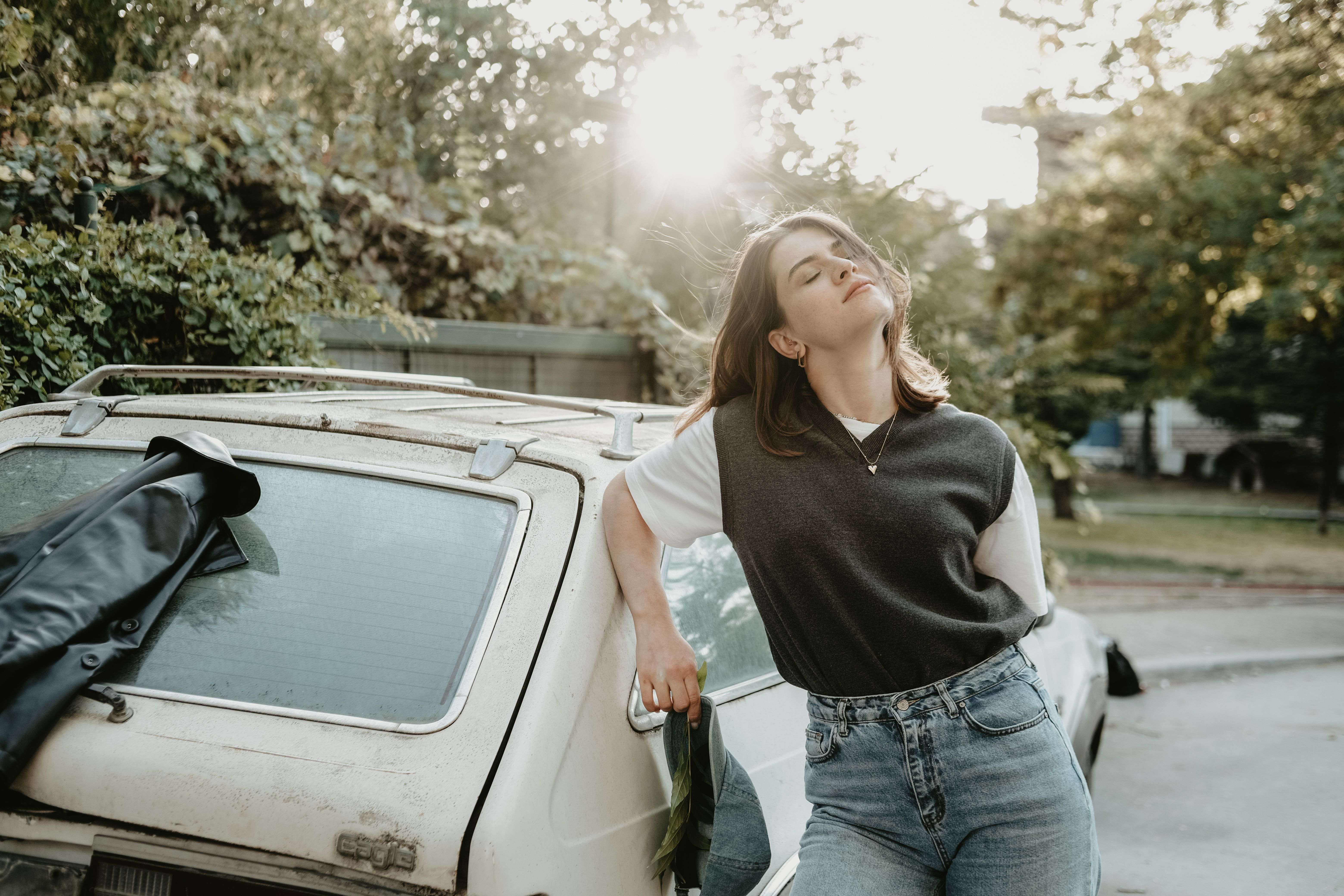 Woman Leaning against a Car in a Morning Light · Free Stock Photo