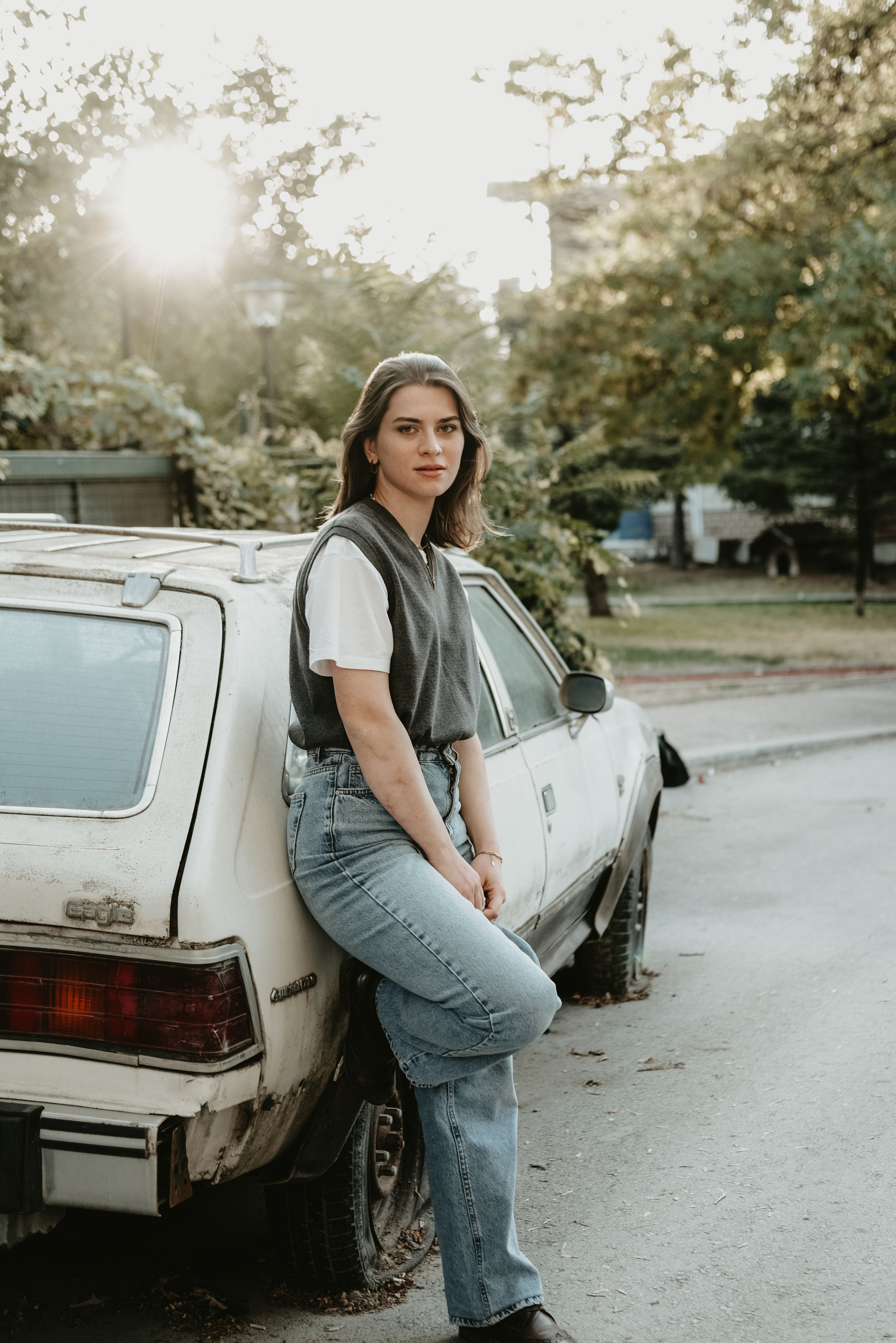 Girl Wearing Jeans Leaning on a Car · Free Stock Photo
