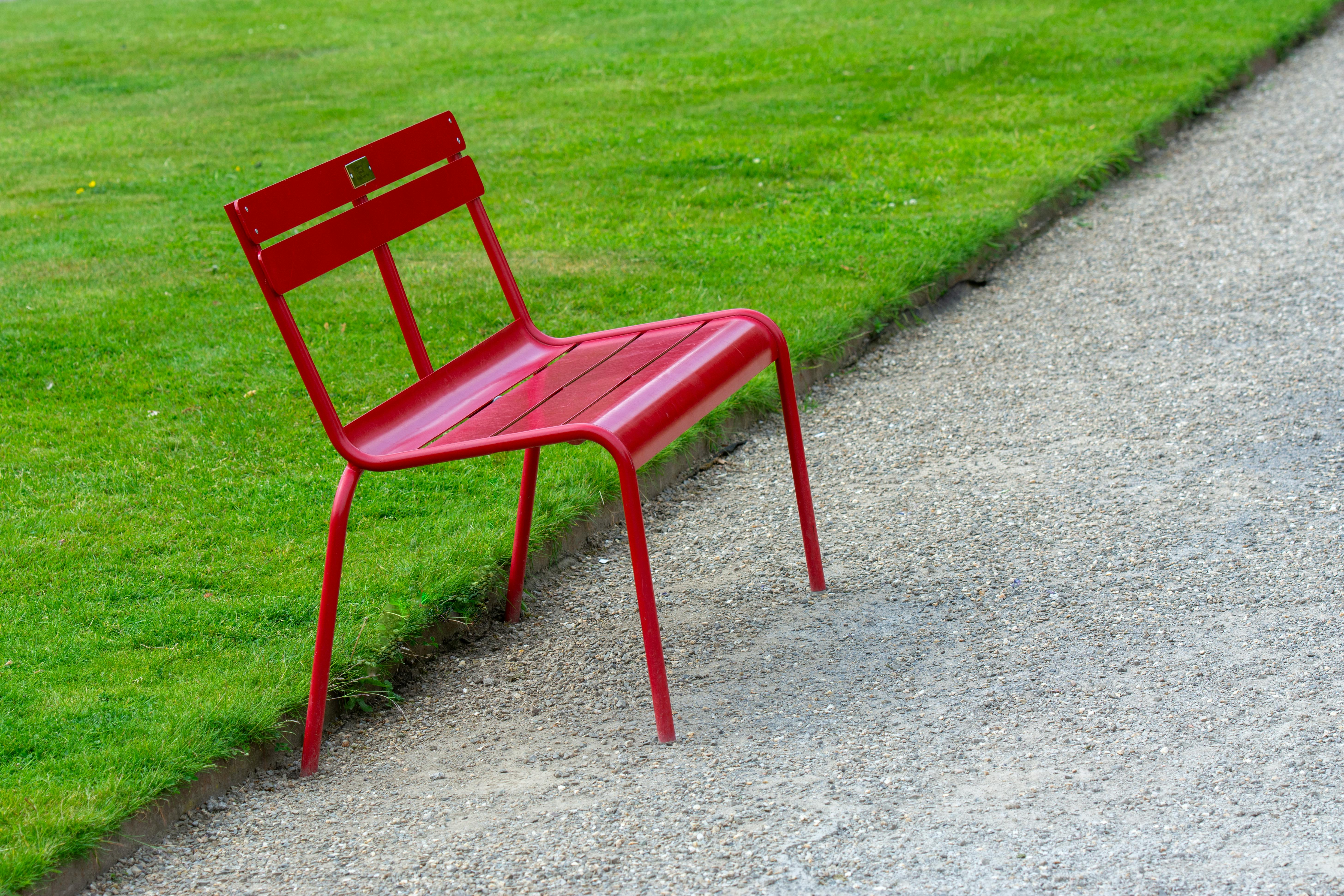 Red Metal Bench against Gray Footpath and Green Grass · Free Stock Photo