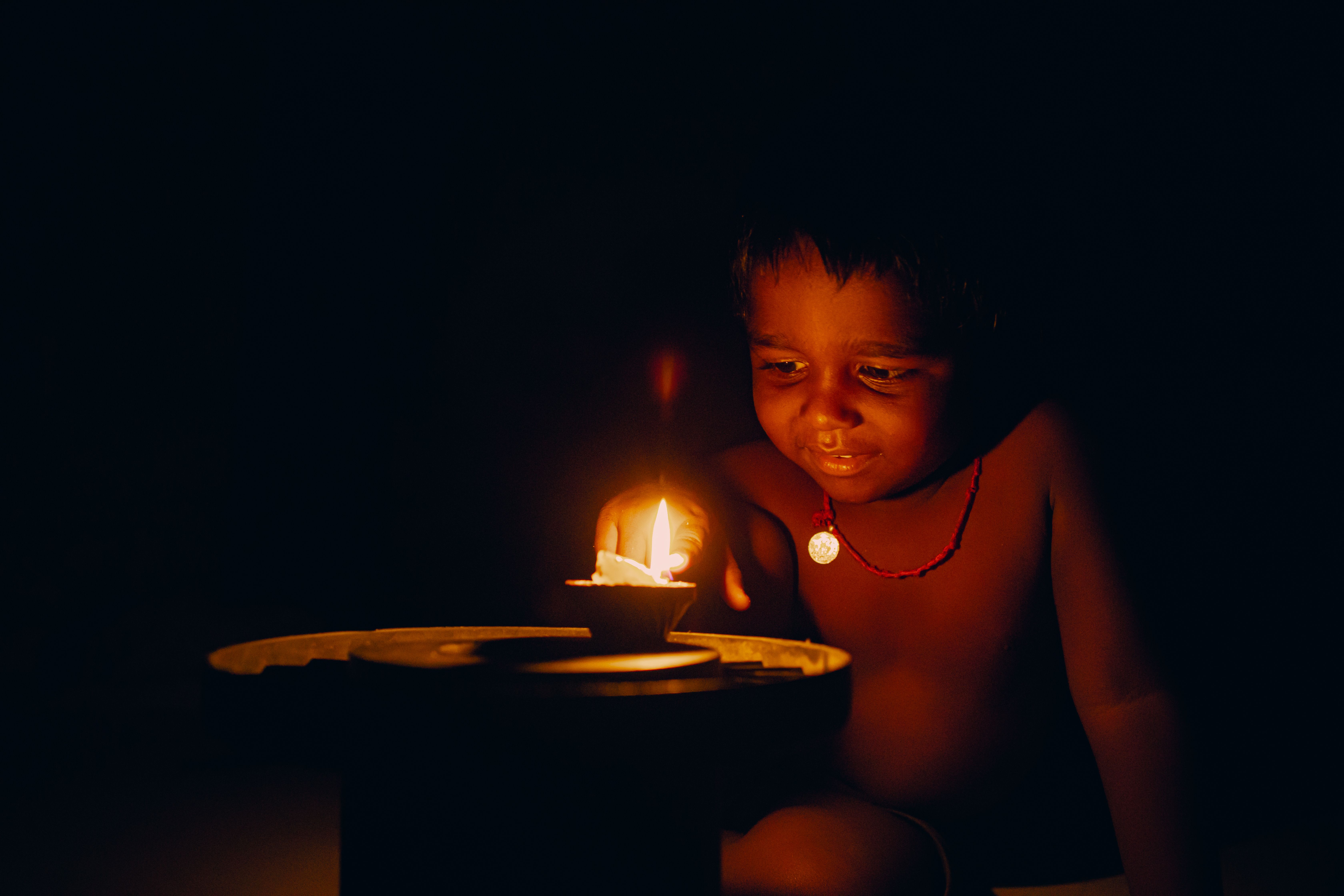 Child Playing with a Candle Flame · Free Stock Photo