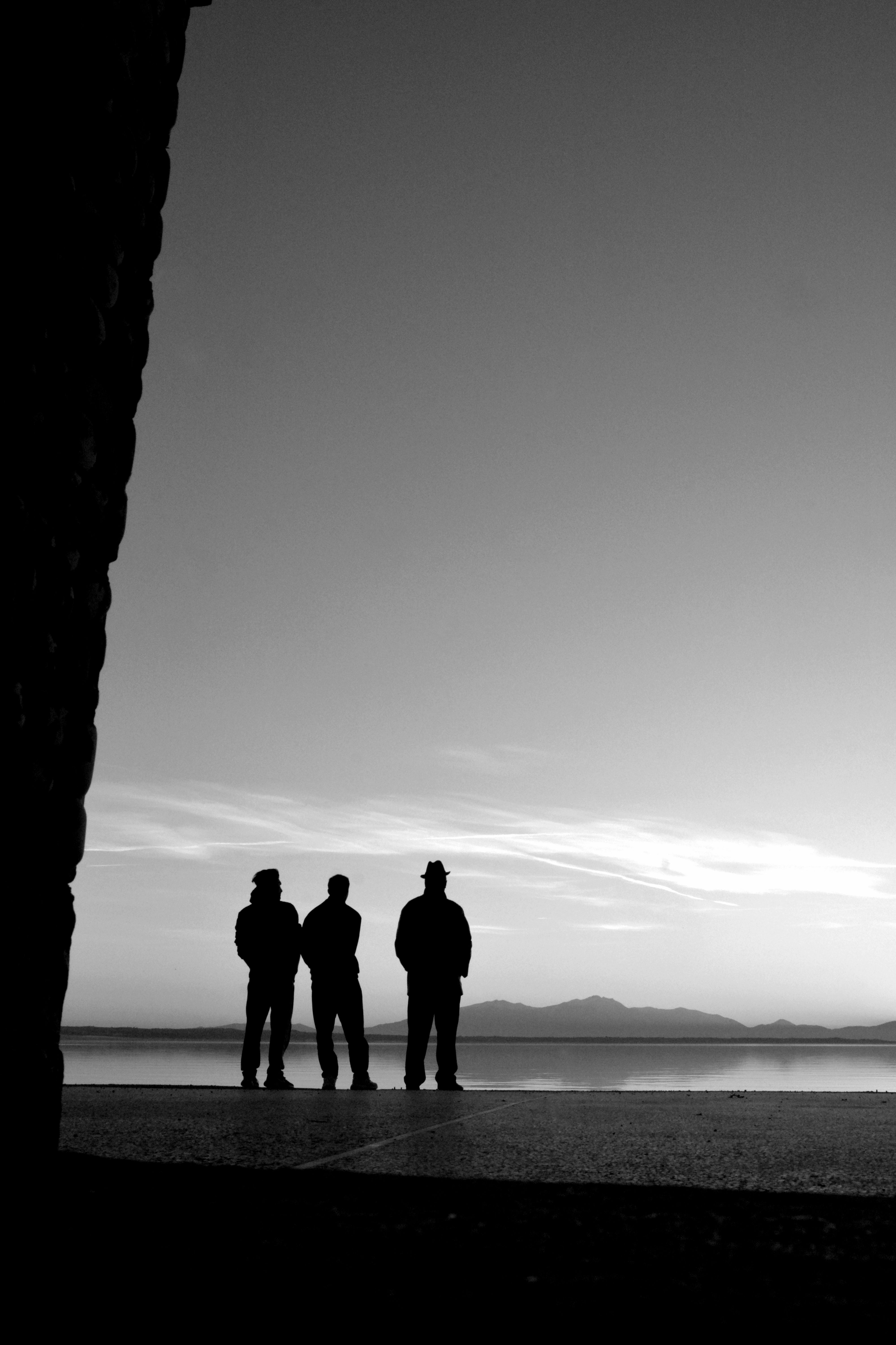 Three people stand in front of a building · Free Stock Photo
