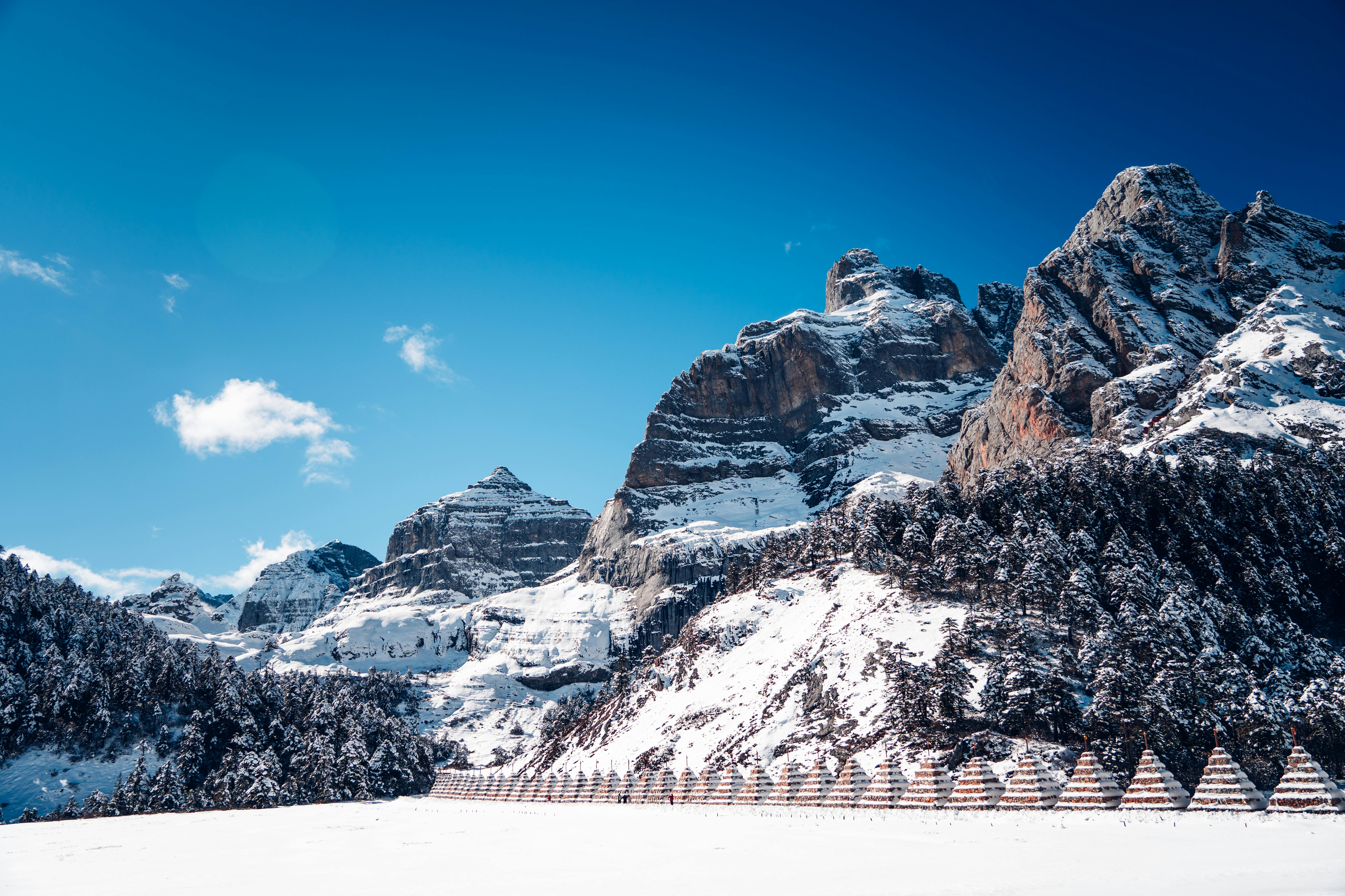 Snowed Alpine Landscape with Mounds of Hay on Meadow · Free Stock Photo