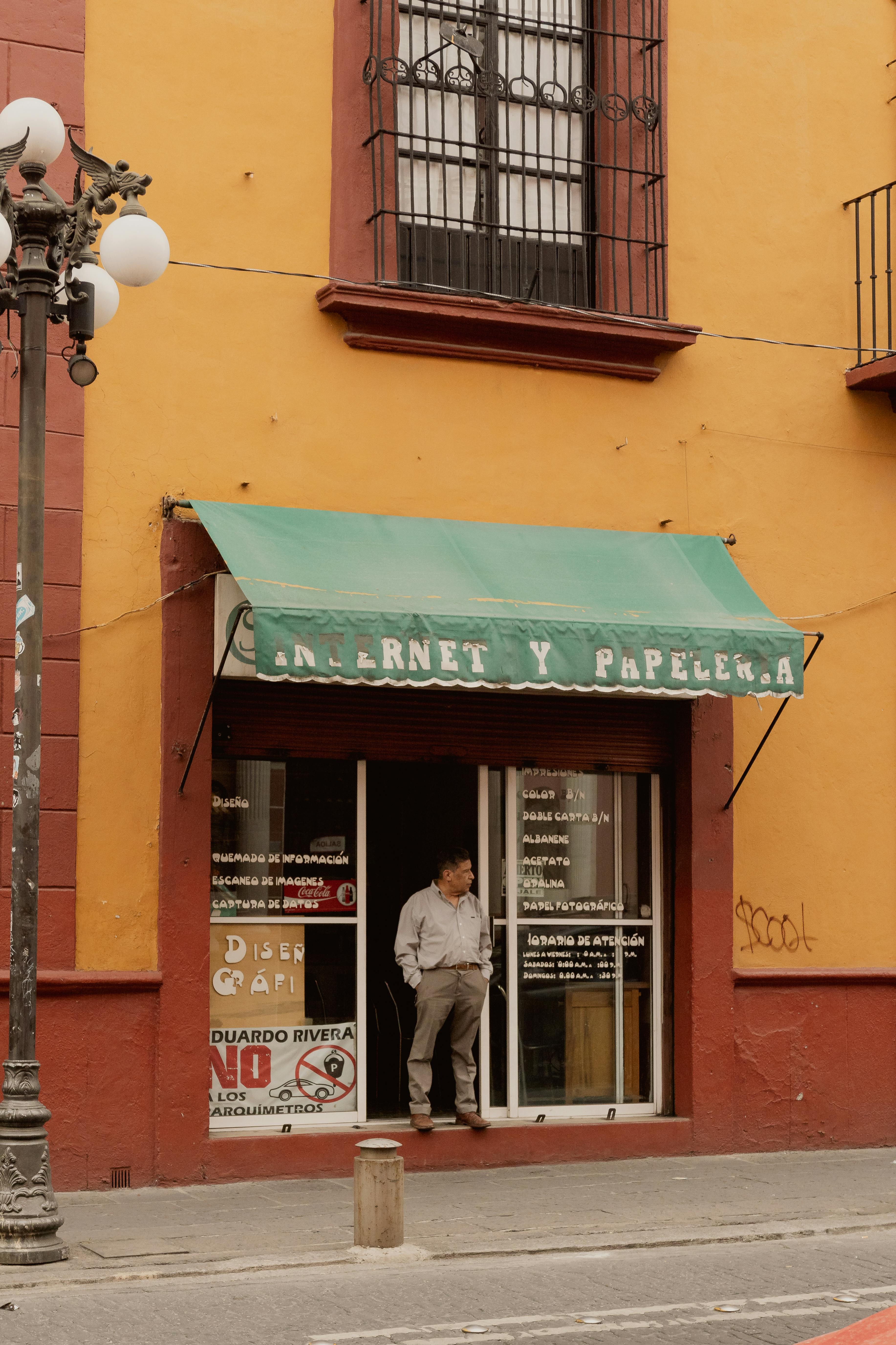Man Standing in Door of a Small Store · Free Stock Photo