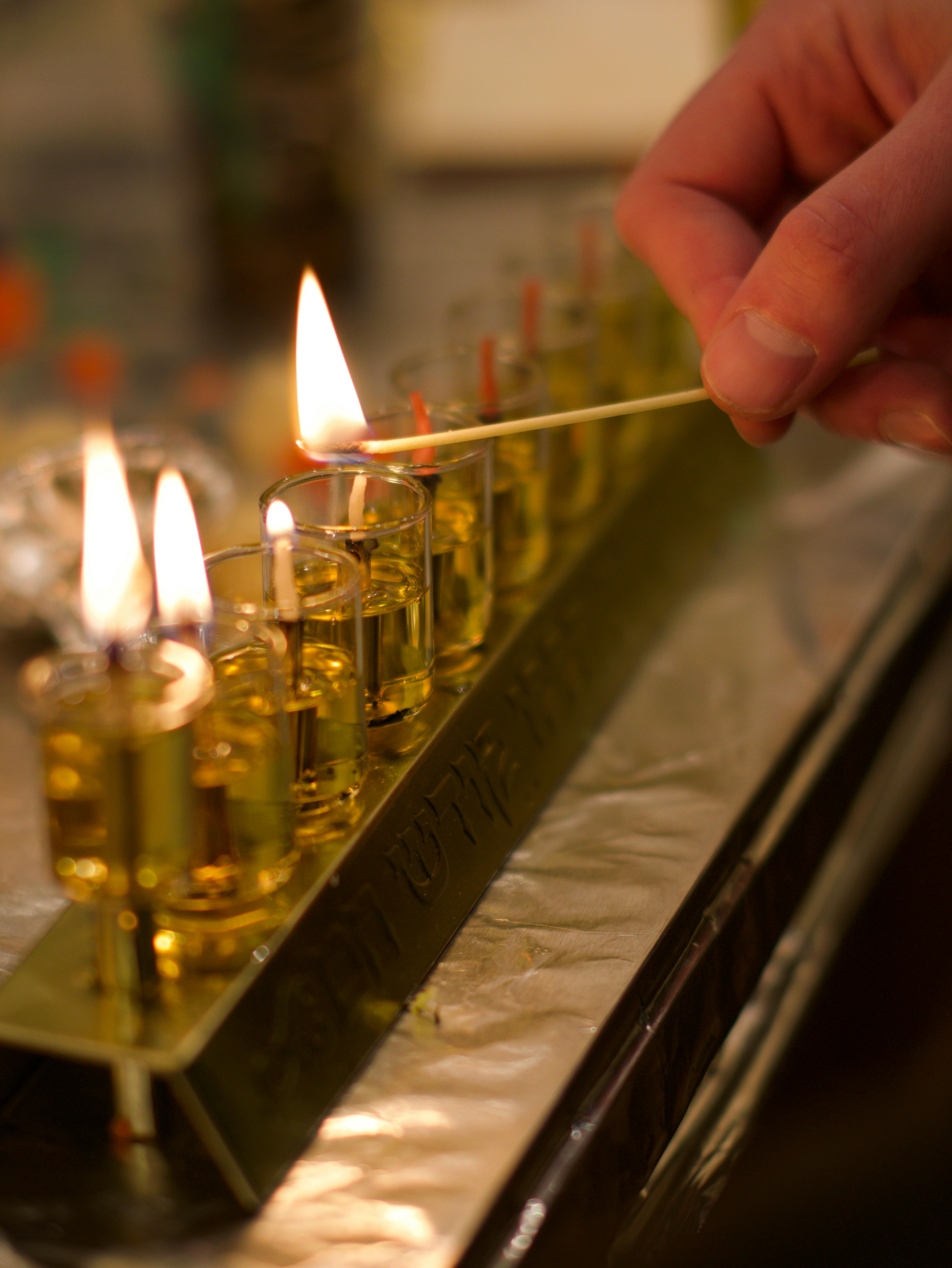 Closeup of a Hand Lighting Liquid Candles · Free Stock Photo