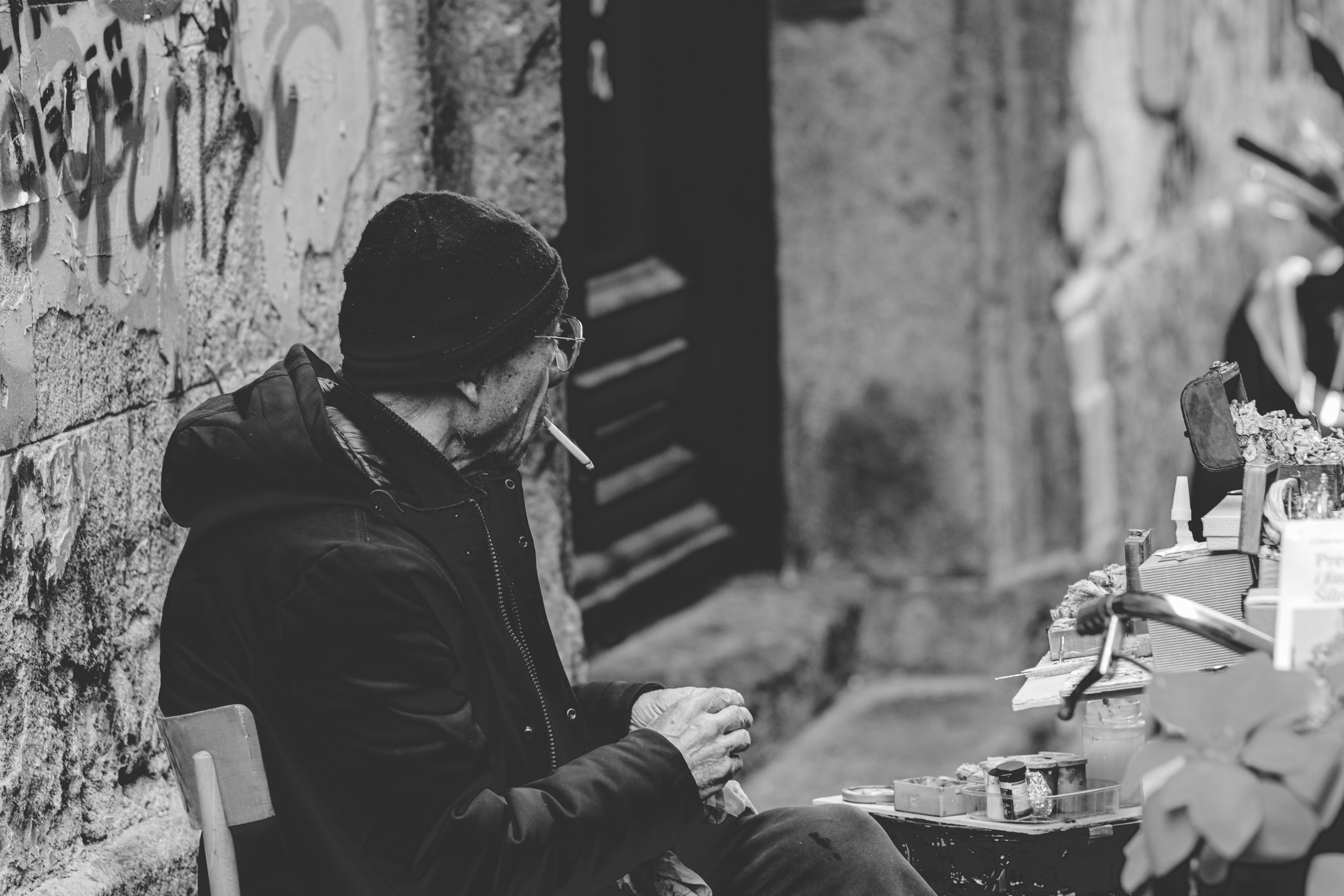 Elderly Man in Beanie Sitting and Smoking Cigarette on Street · Free ...