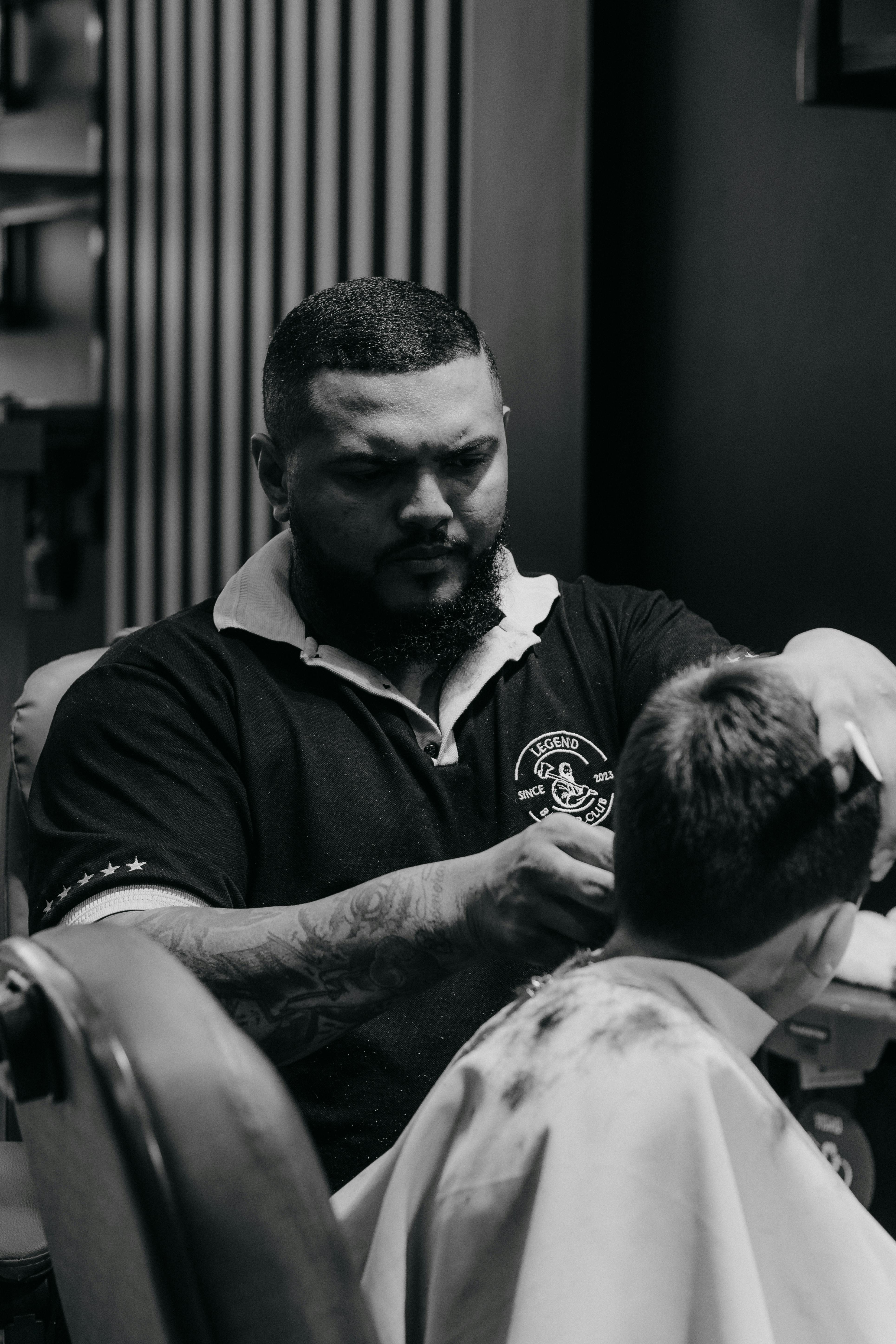 A man getting his hair cut by another man · Free Stock Photo