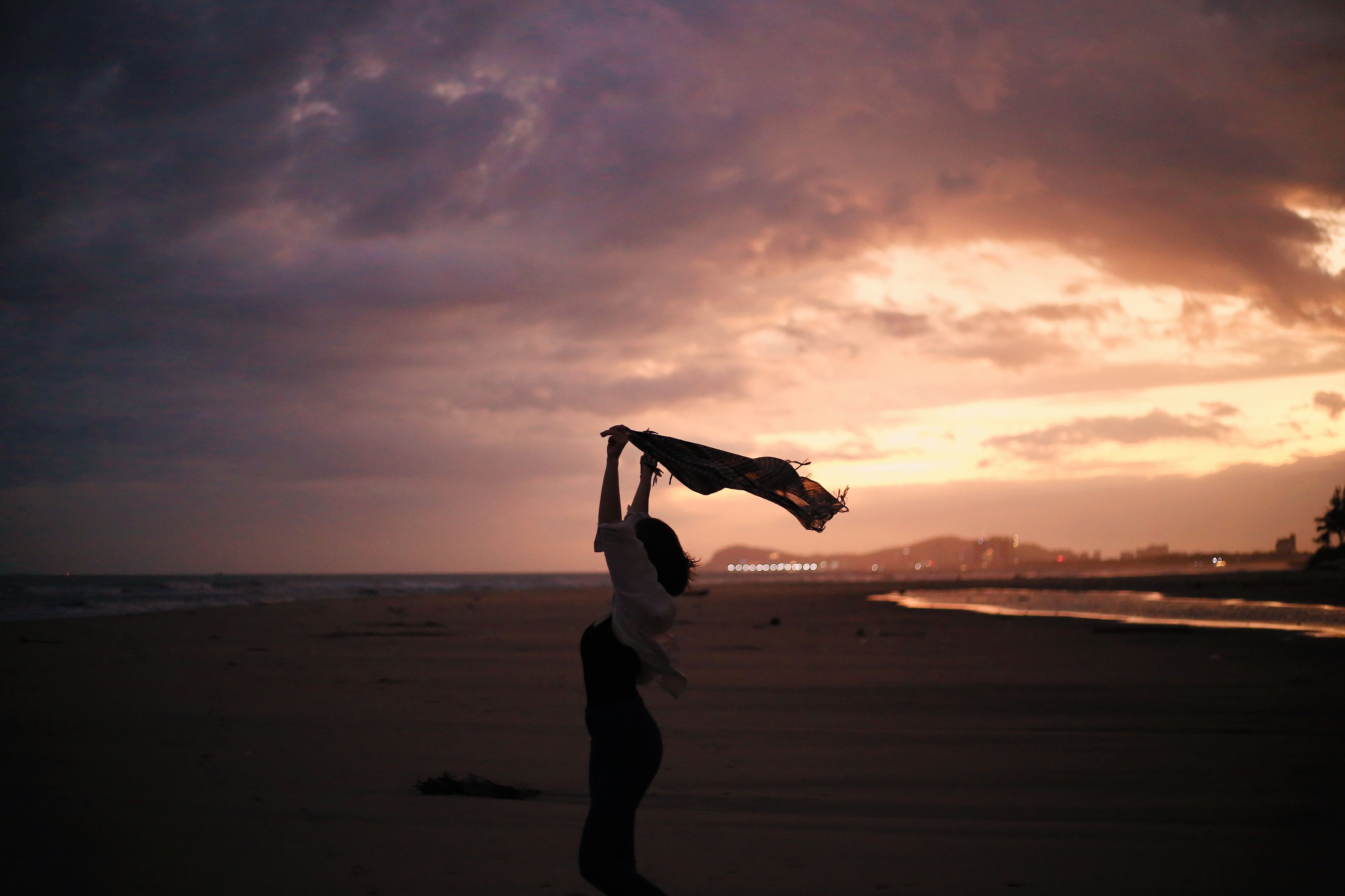 Woman Enjoying Wind at Beach under Storm Clouds · Free Stock Photo