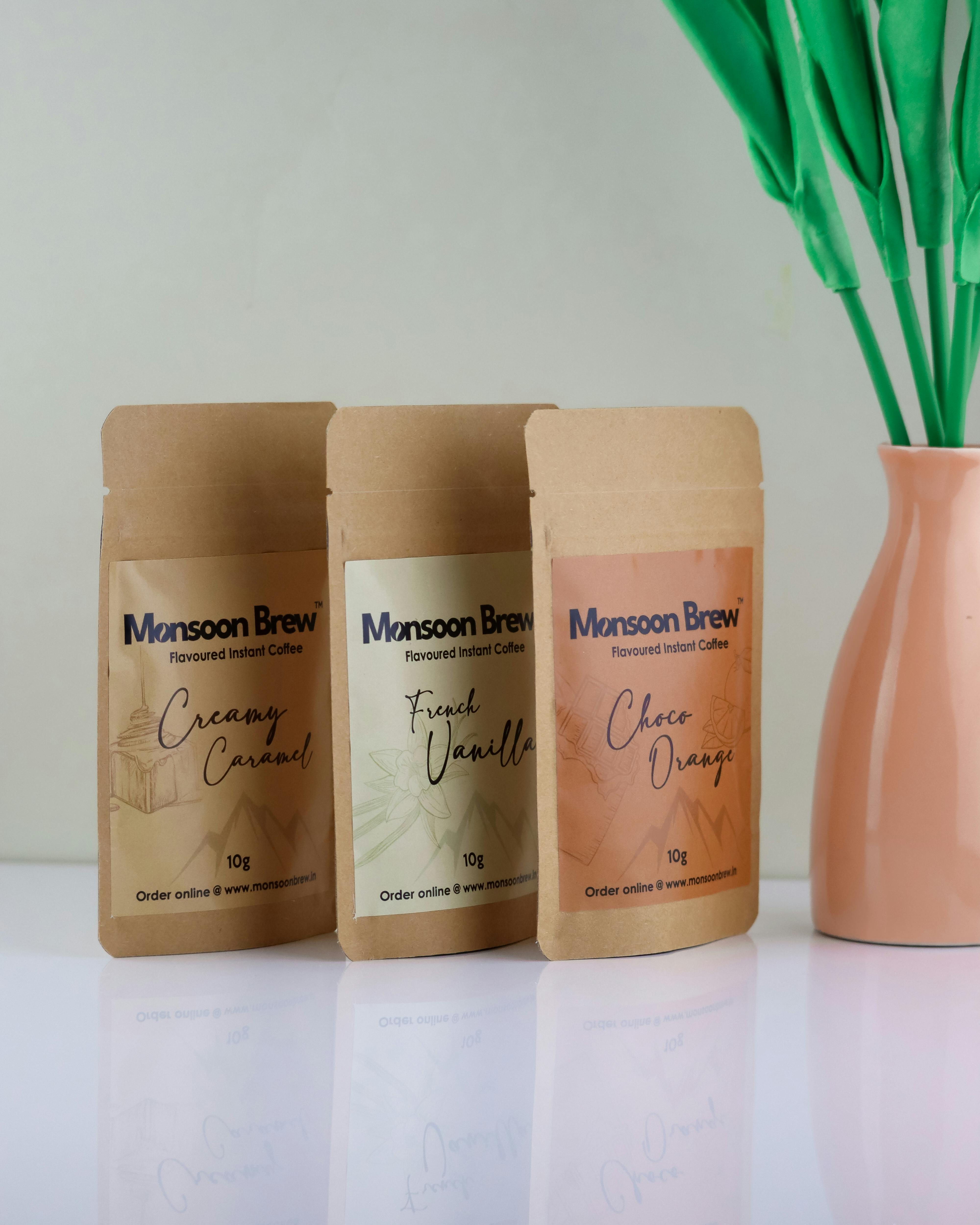 Packages of Coffee near Vase with Plant · Free Stock Photo