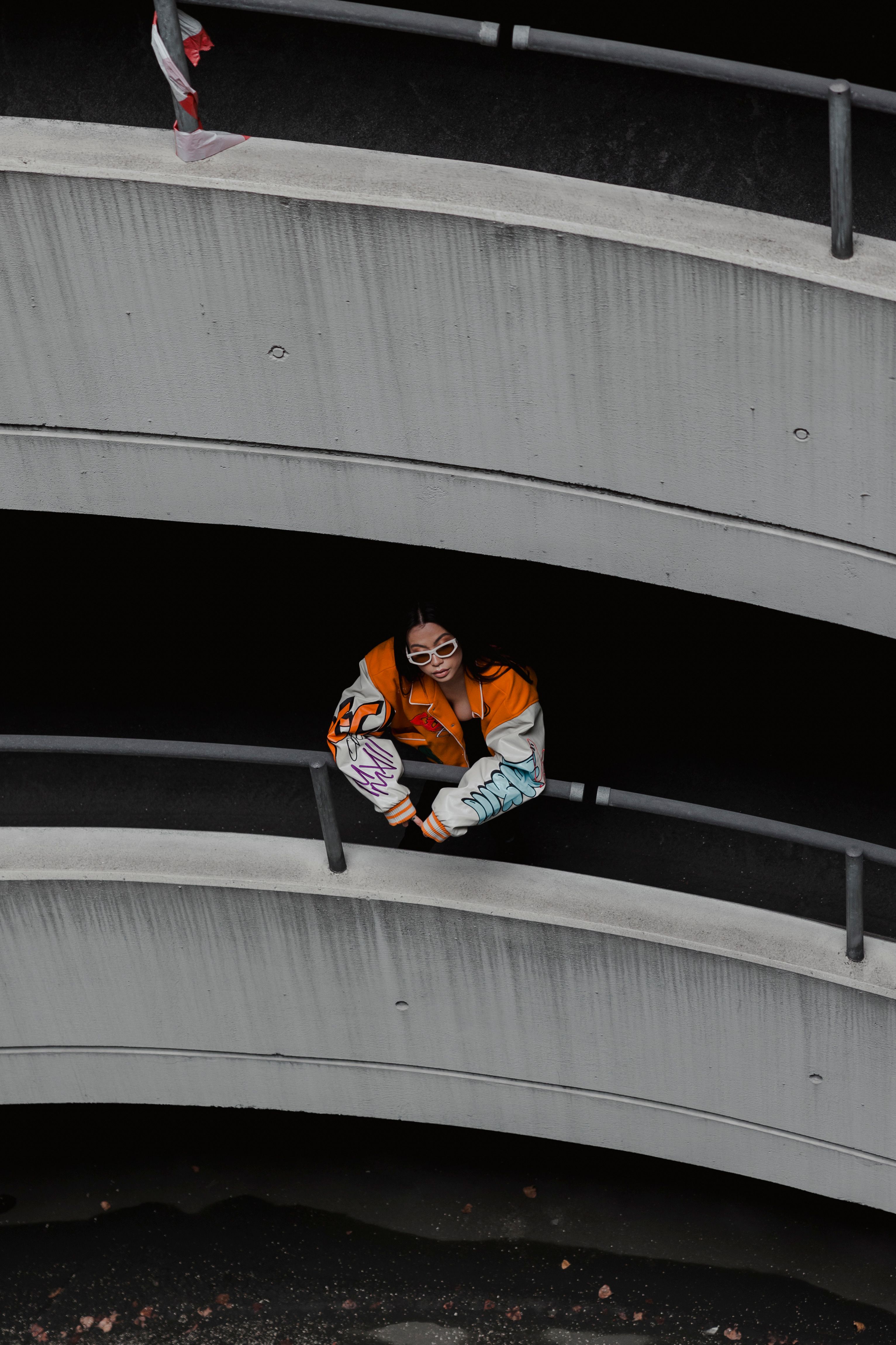 Woman Wearing Orange Jacket on a Balcony · Free Stock Photo