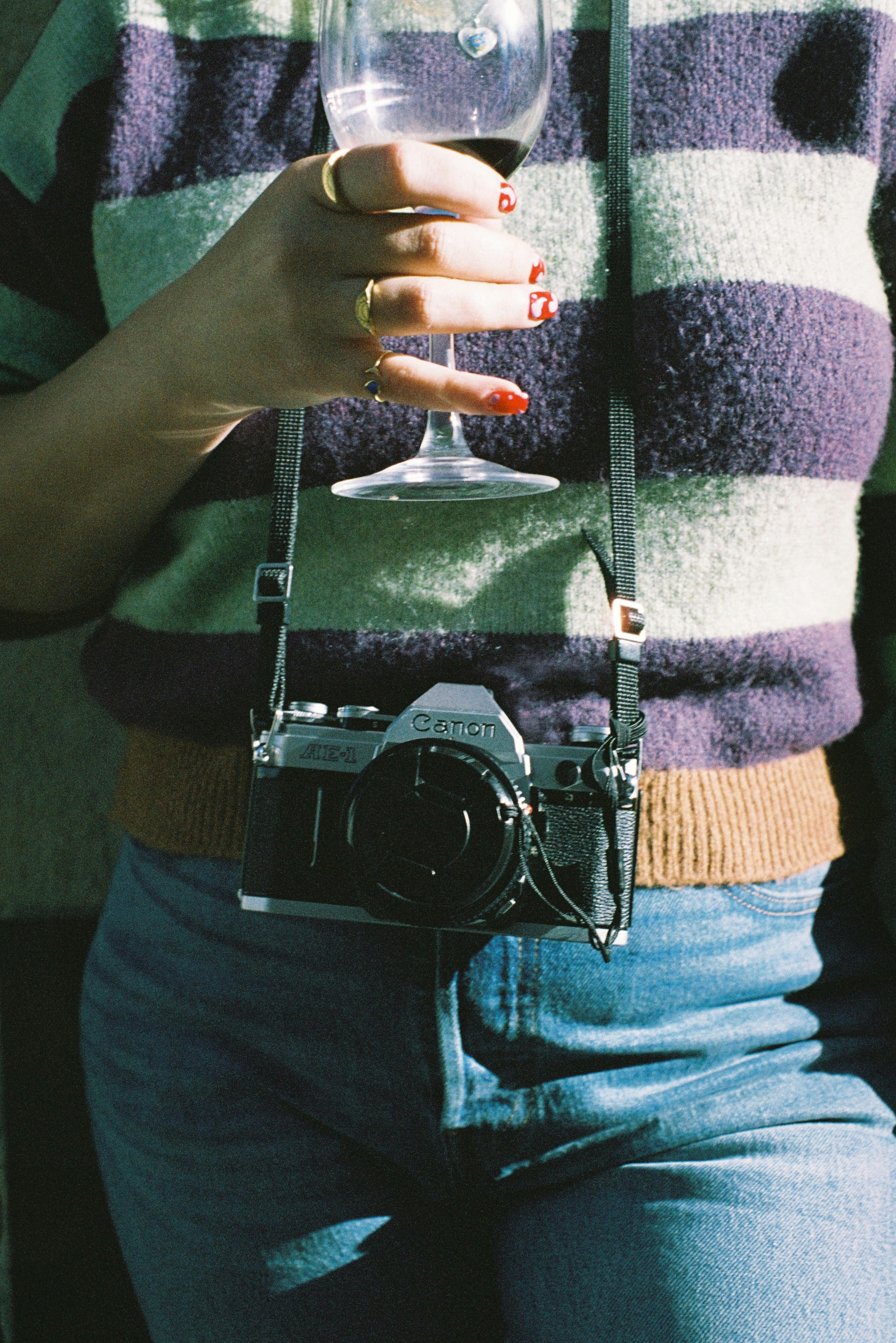Woman Hand Holding Wine Glass over Camera · Free Stock Photo