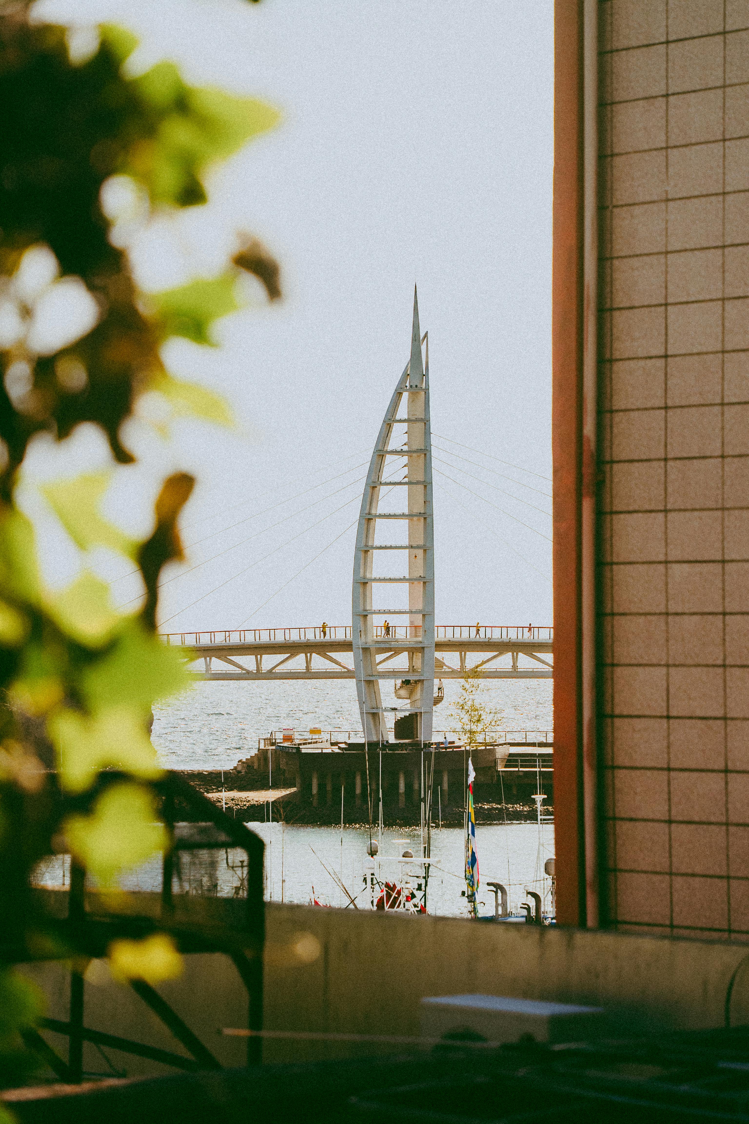 Pylon behind Building on Sea Coast · Free Stock Photo