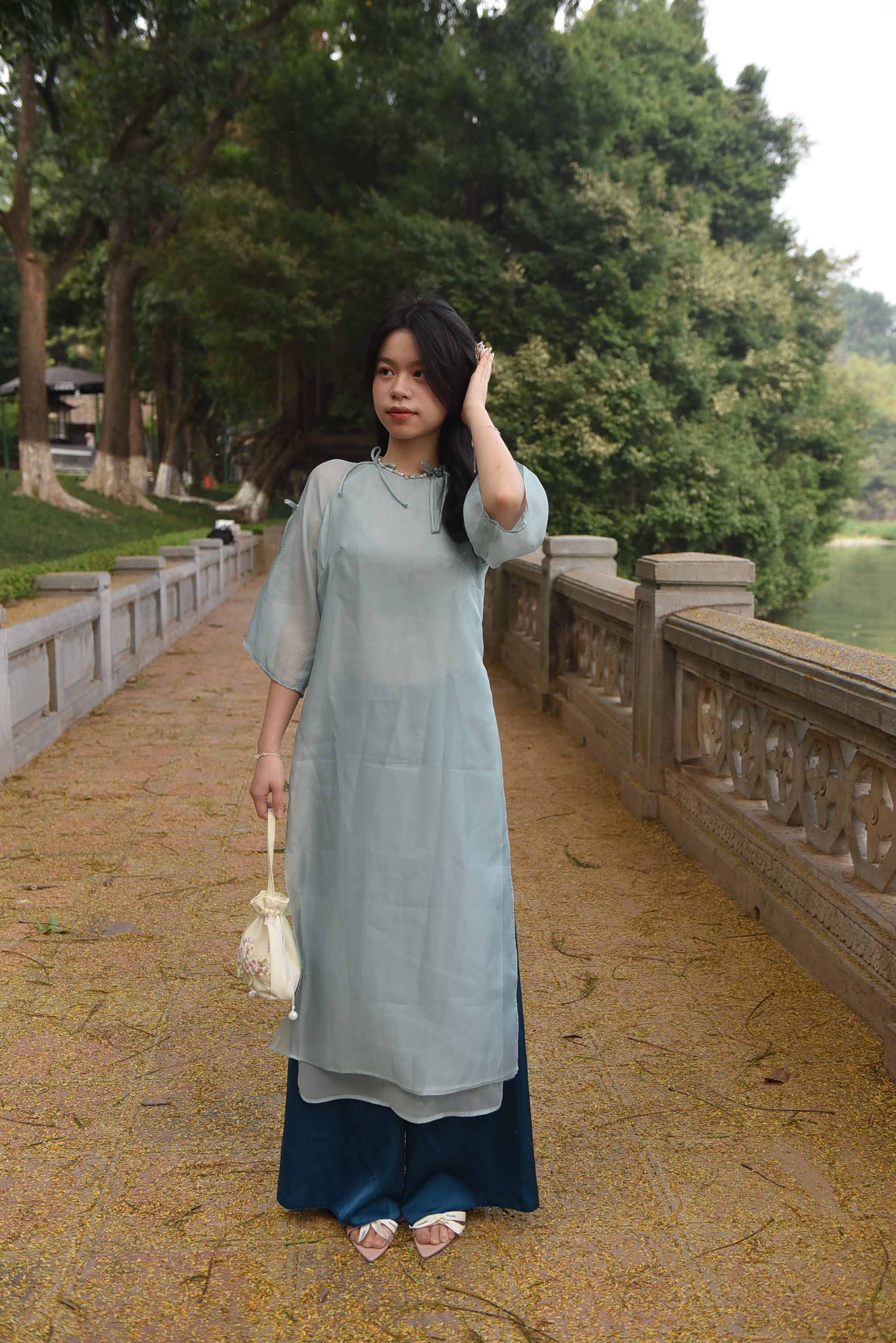 Woman in Loose Dress Standing in Park by Lake Shore · Free Stock Photo