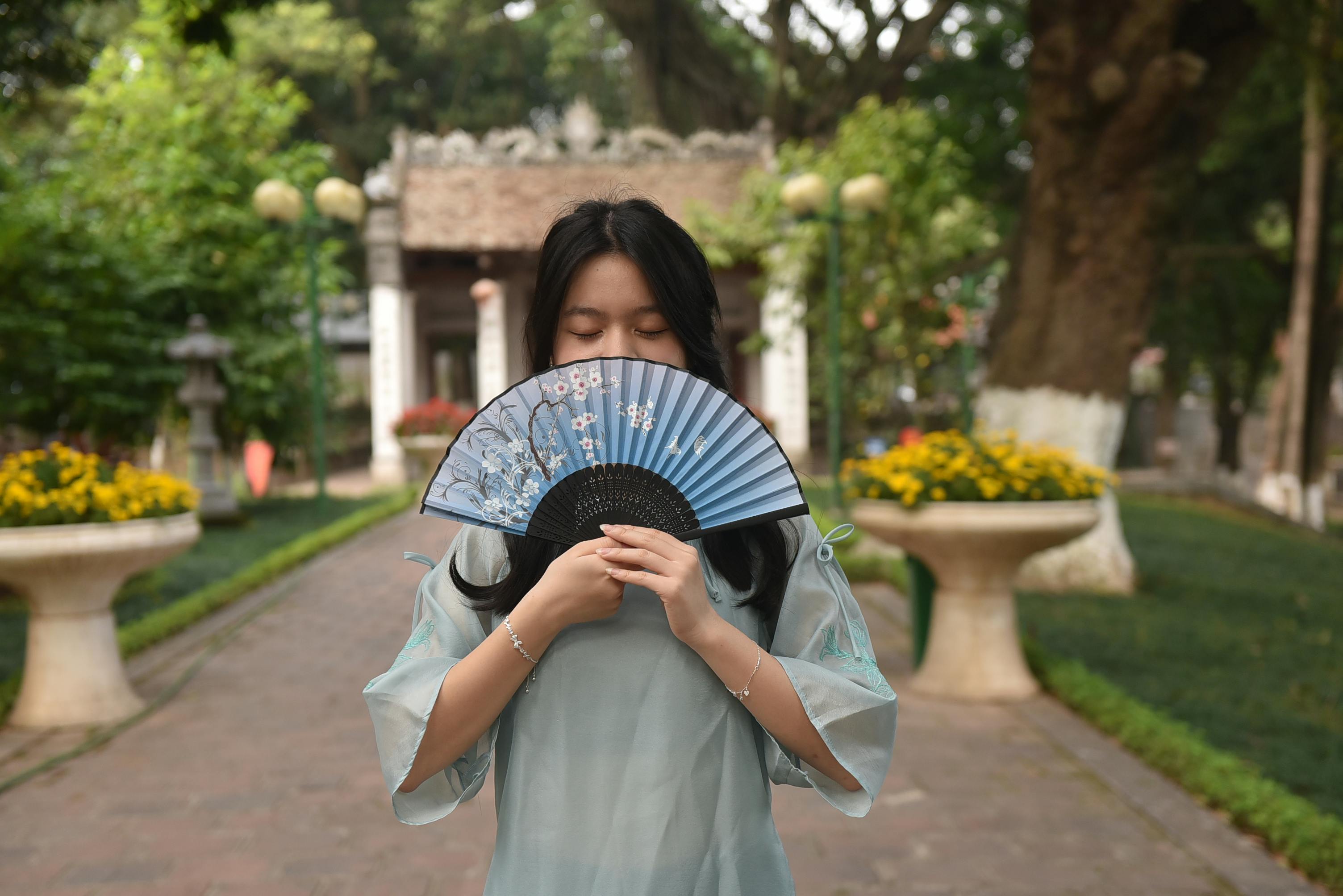 Woman Hiding Face behind Paper Fan · Free Stock Photo