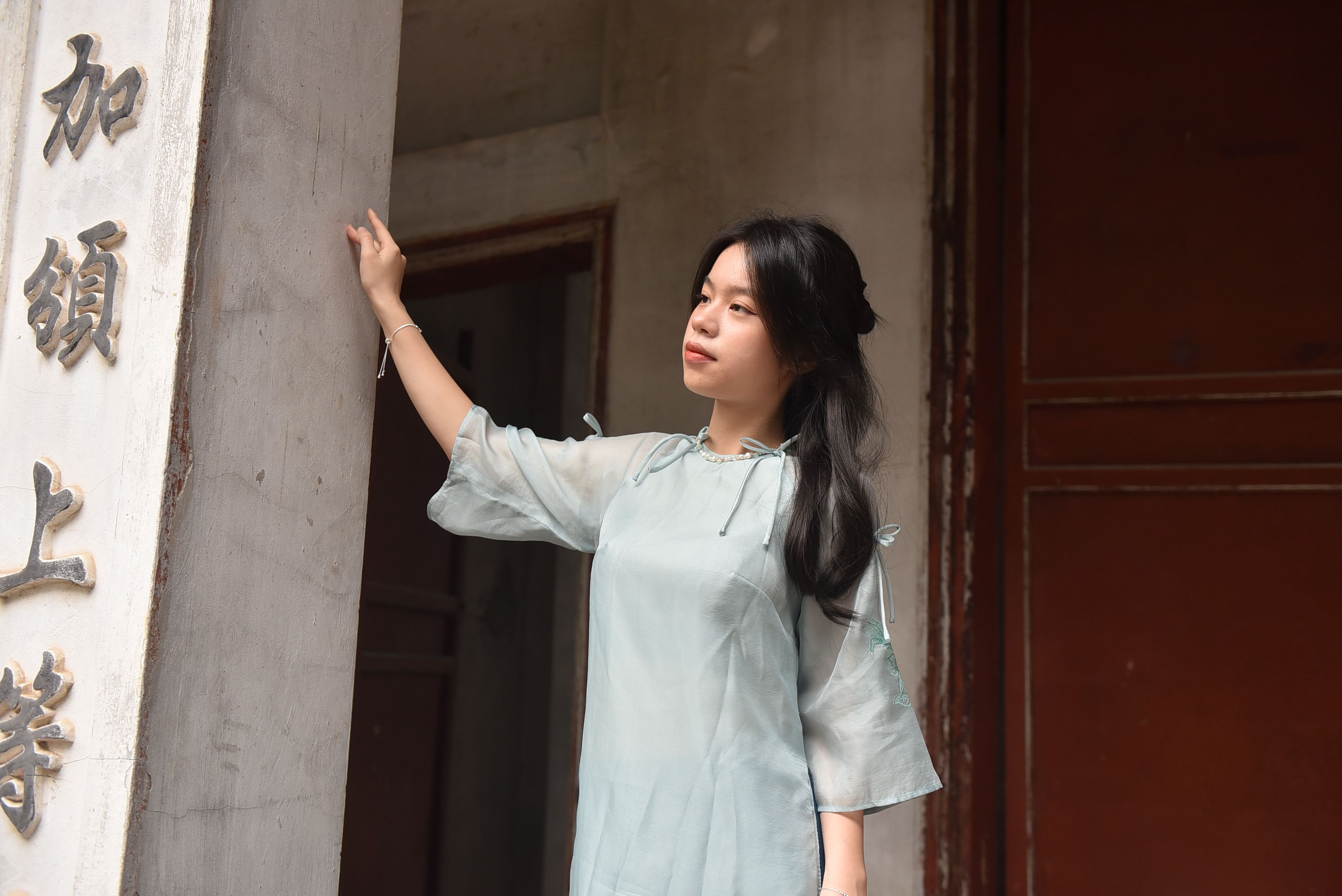 Woman in Loose Dress Standing by House Entrance · Free Stock Photo