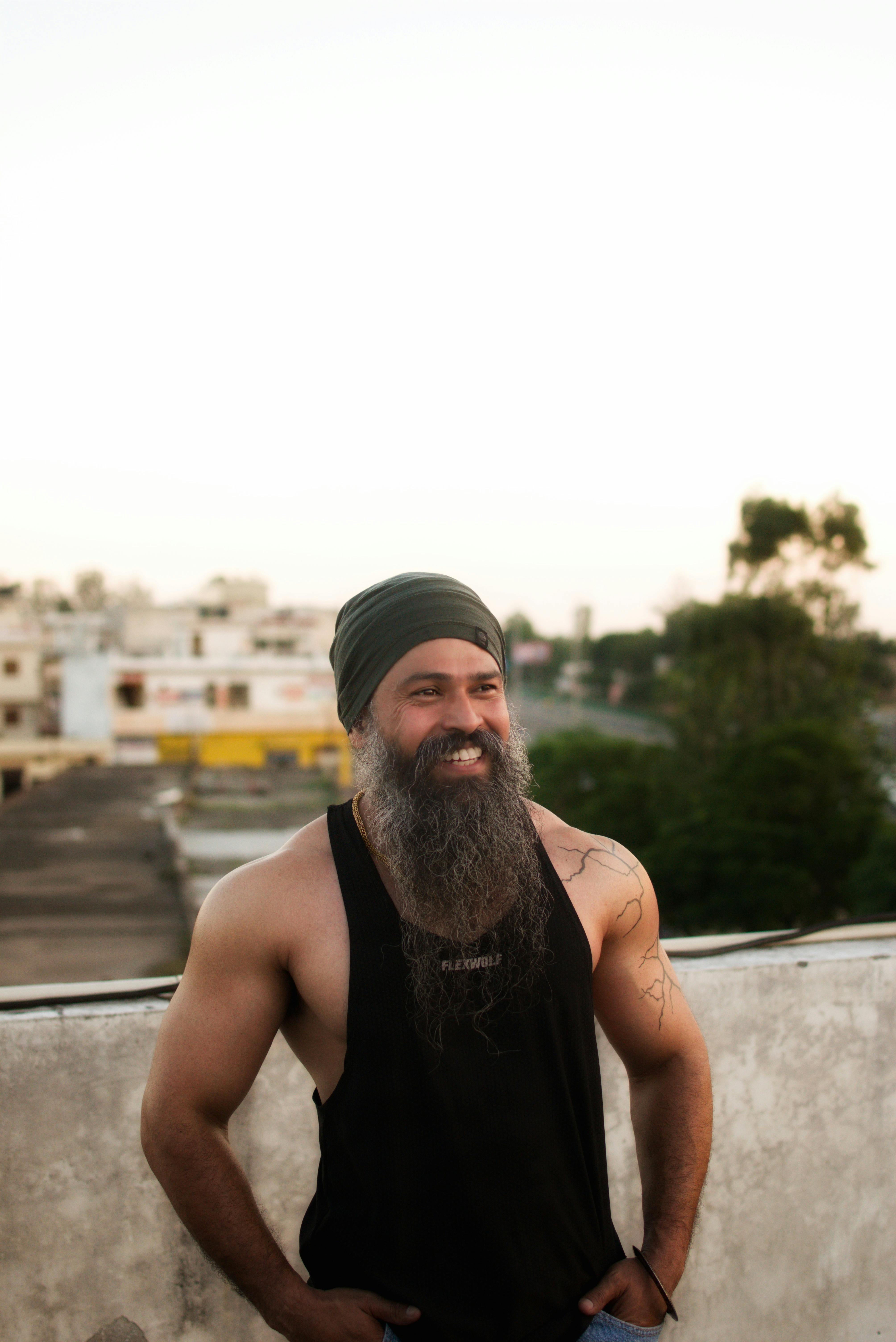 Smiling Bearded Man in Tank Top and Hat · Free Stock Photo