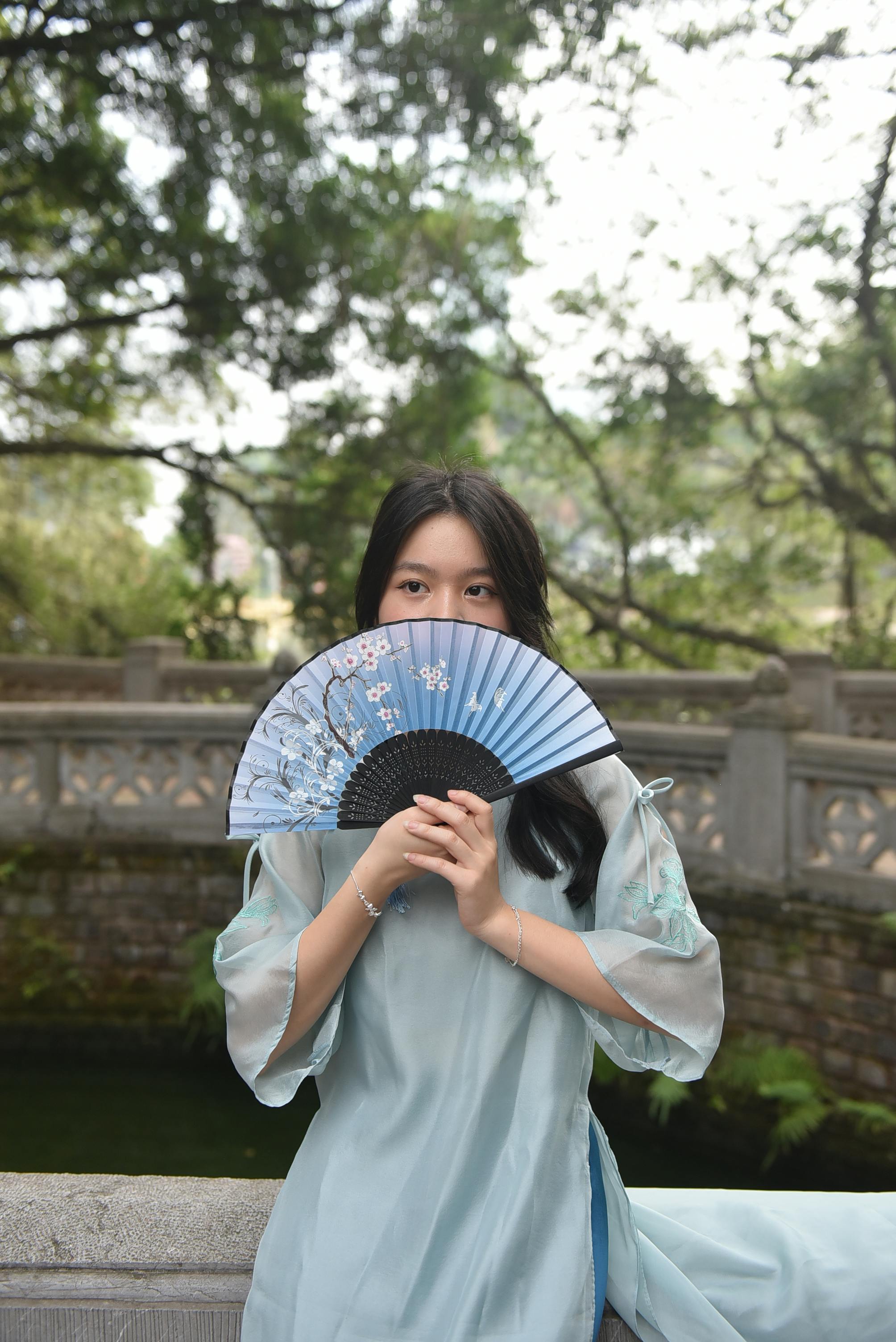 Brunette Posing with Fan, Wearing Traditional Clothing · Free Stock Photo