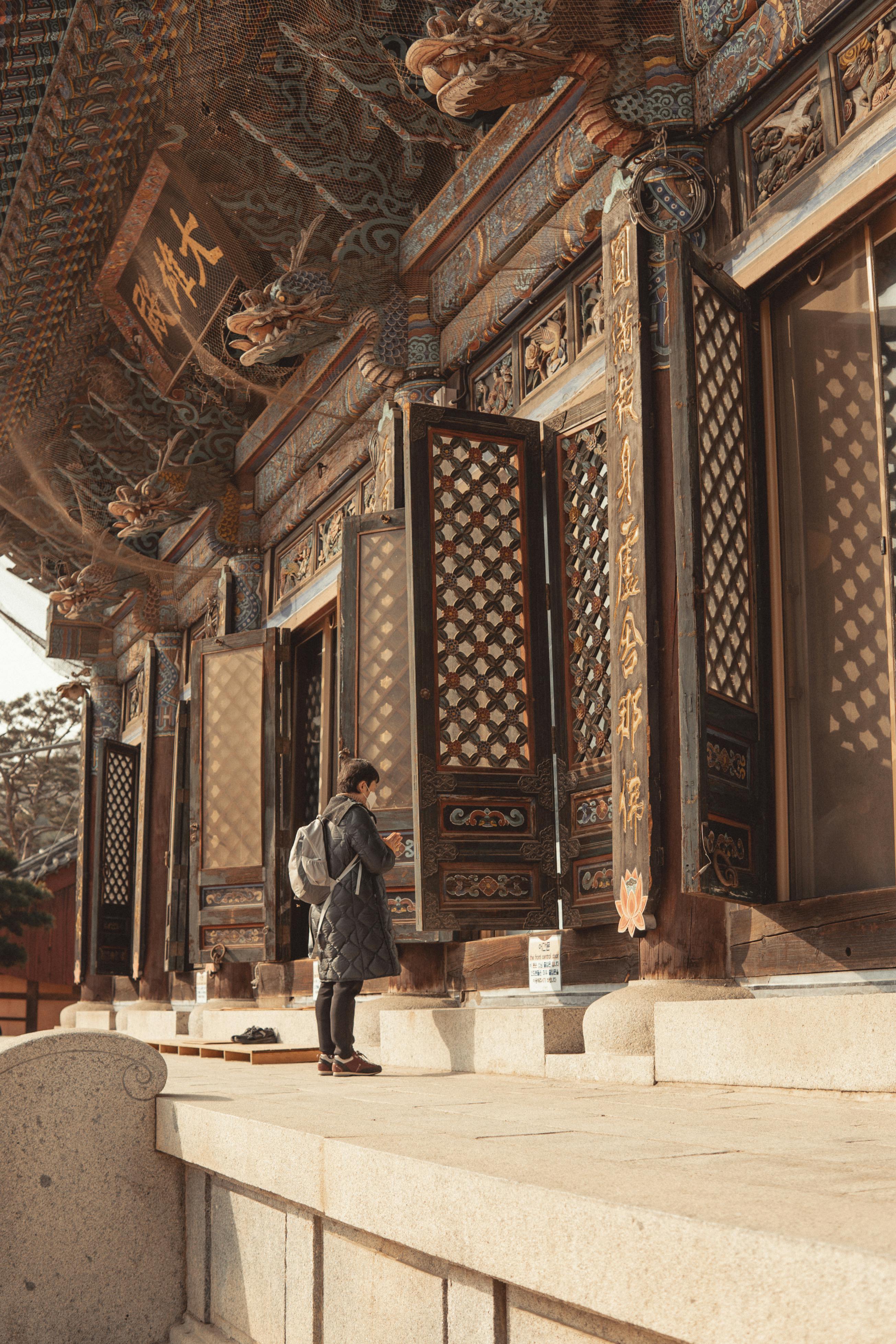 Woman Standing and Praying in front of a Temple · Free Stock Photo