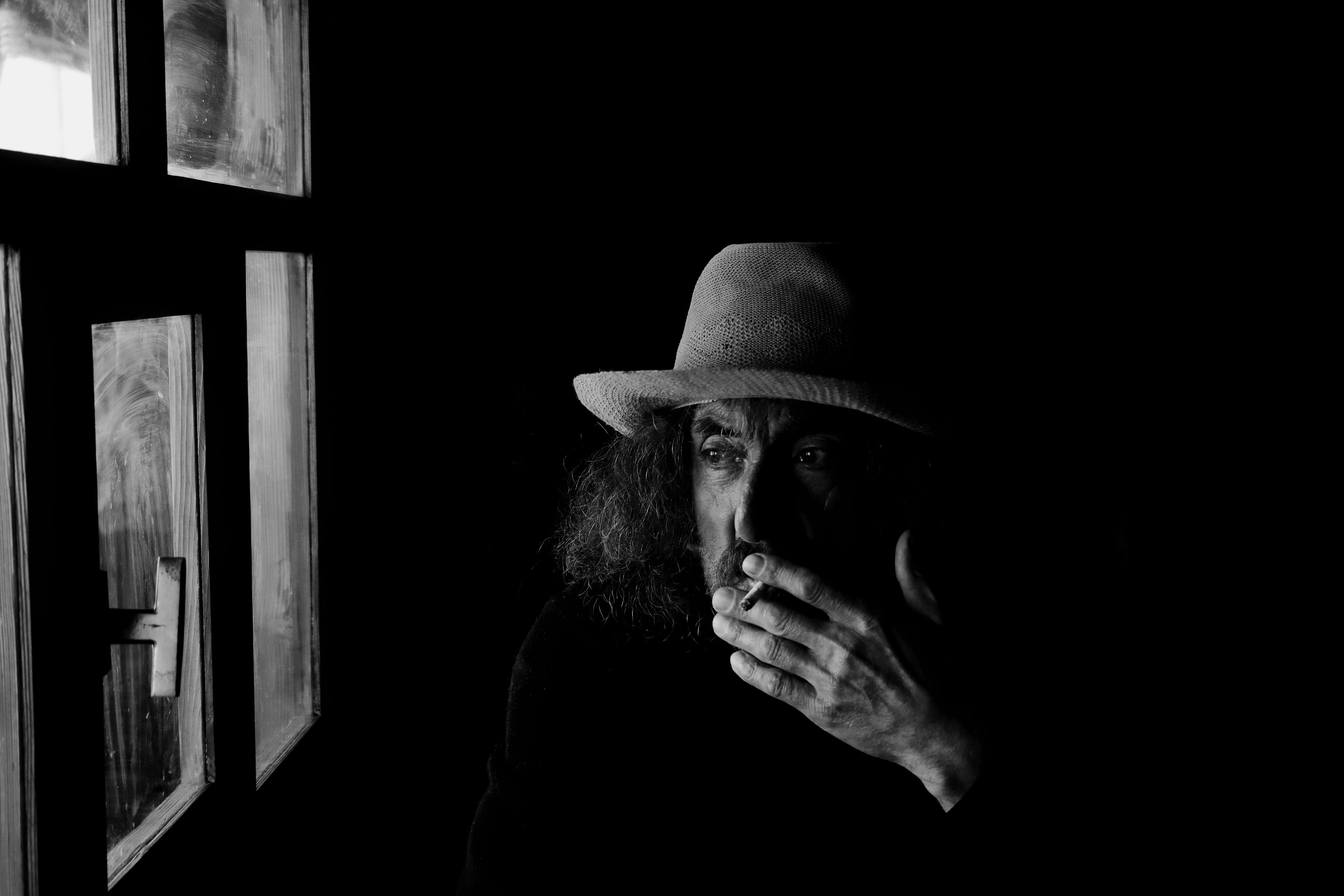 A Man Smoking by a Window · Free Stock Photo