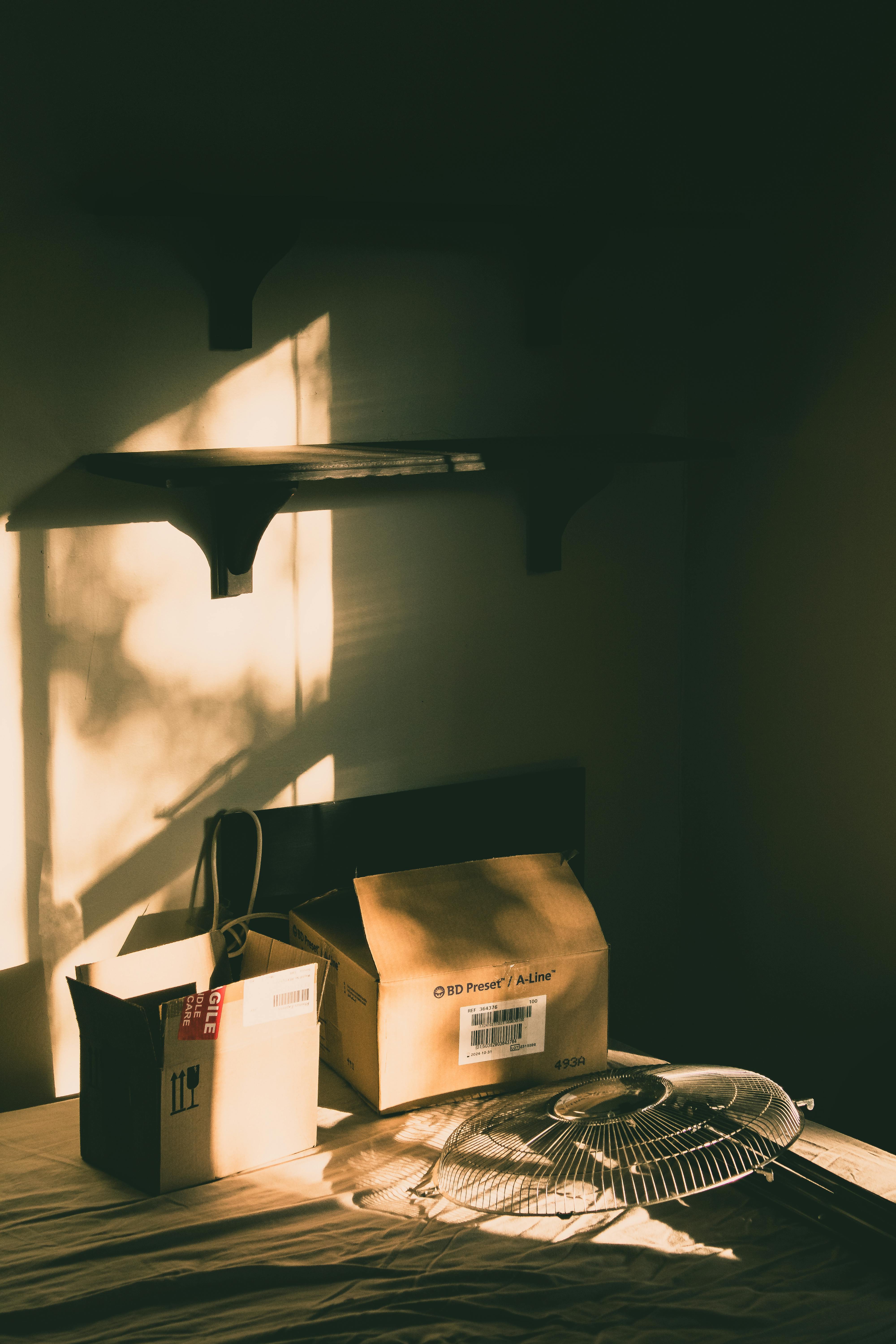 Cardboard Boxes Lying on a Table in Sunlight · Free Stock Photo
