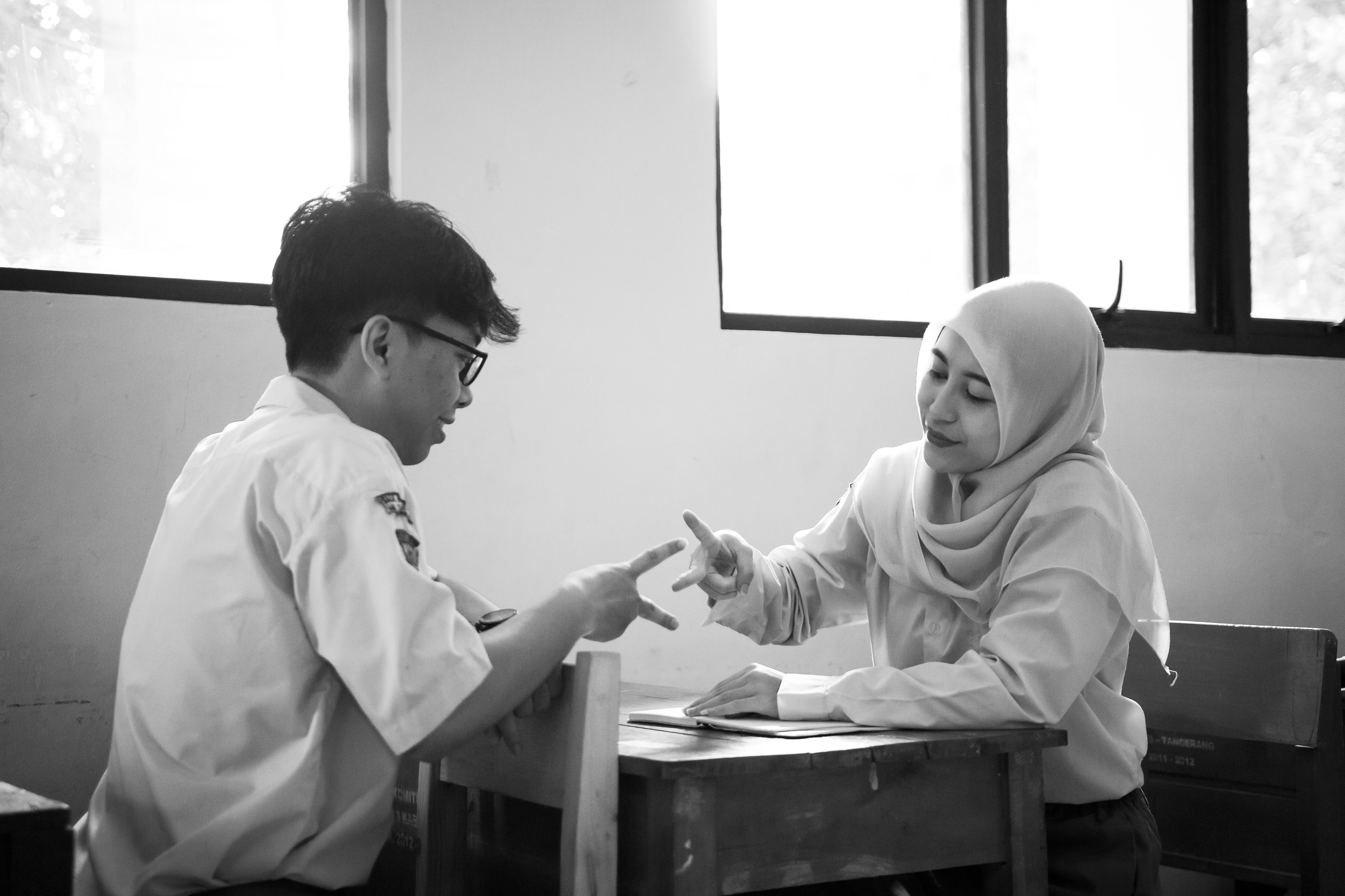 Smiling Students Talking at a Desk in Class · Free Stock Photo