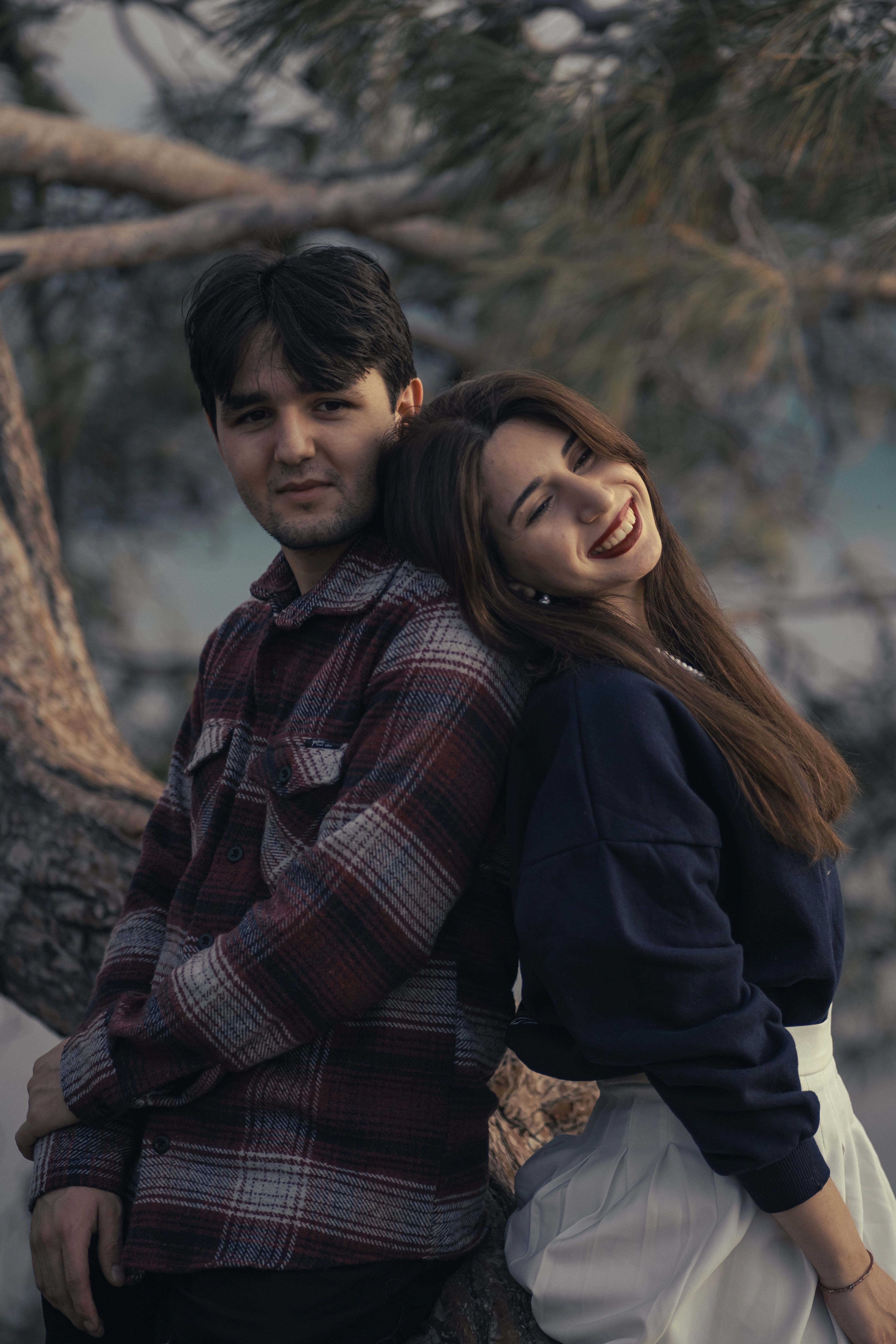 A Couple Standing Back to Back and Smiling · Free Stock Photo