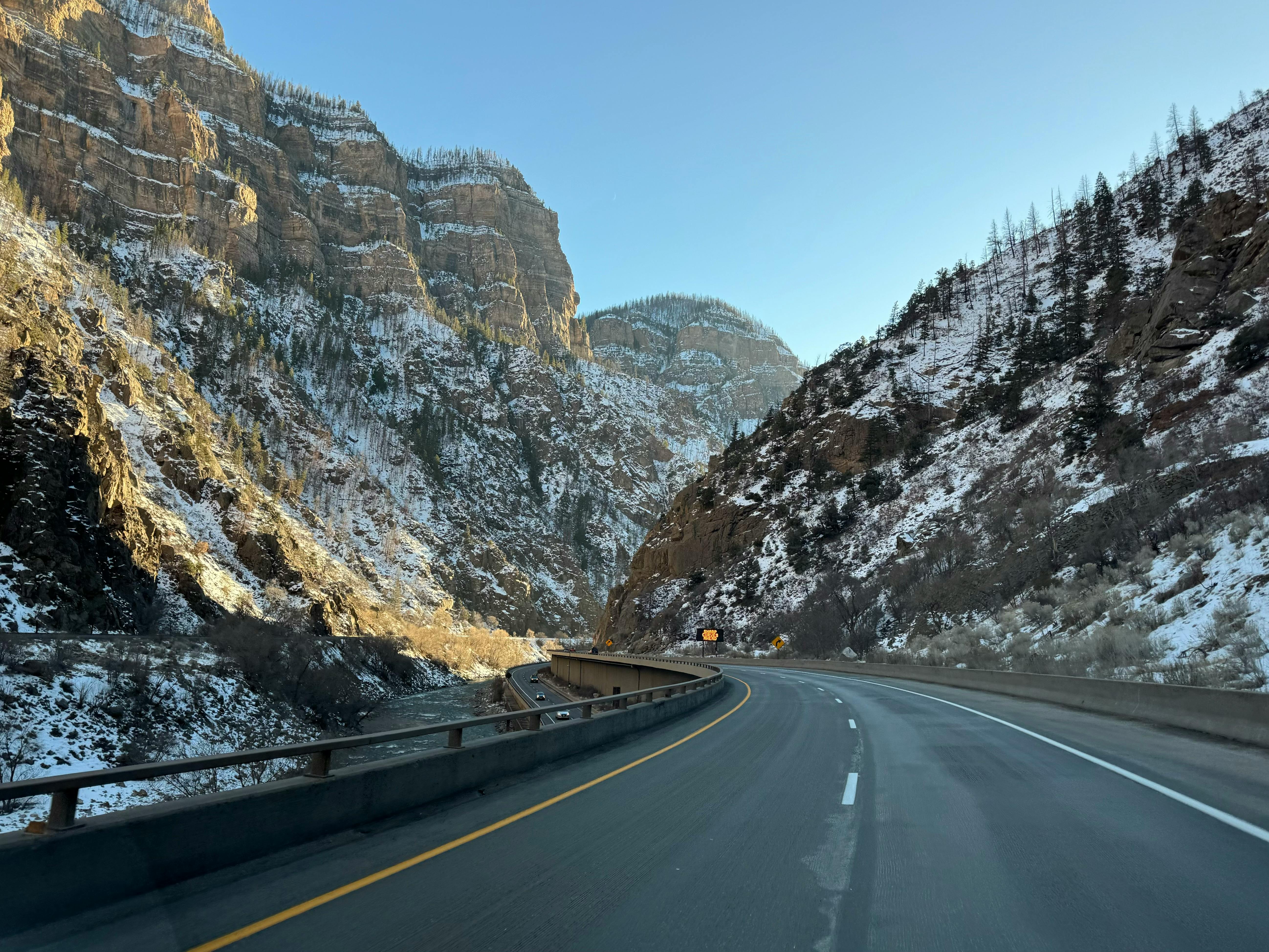 A highway with snow covered mountains in the background · Free Stock Photo