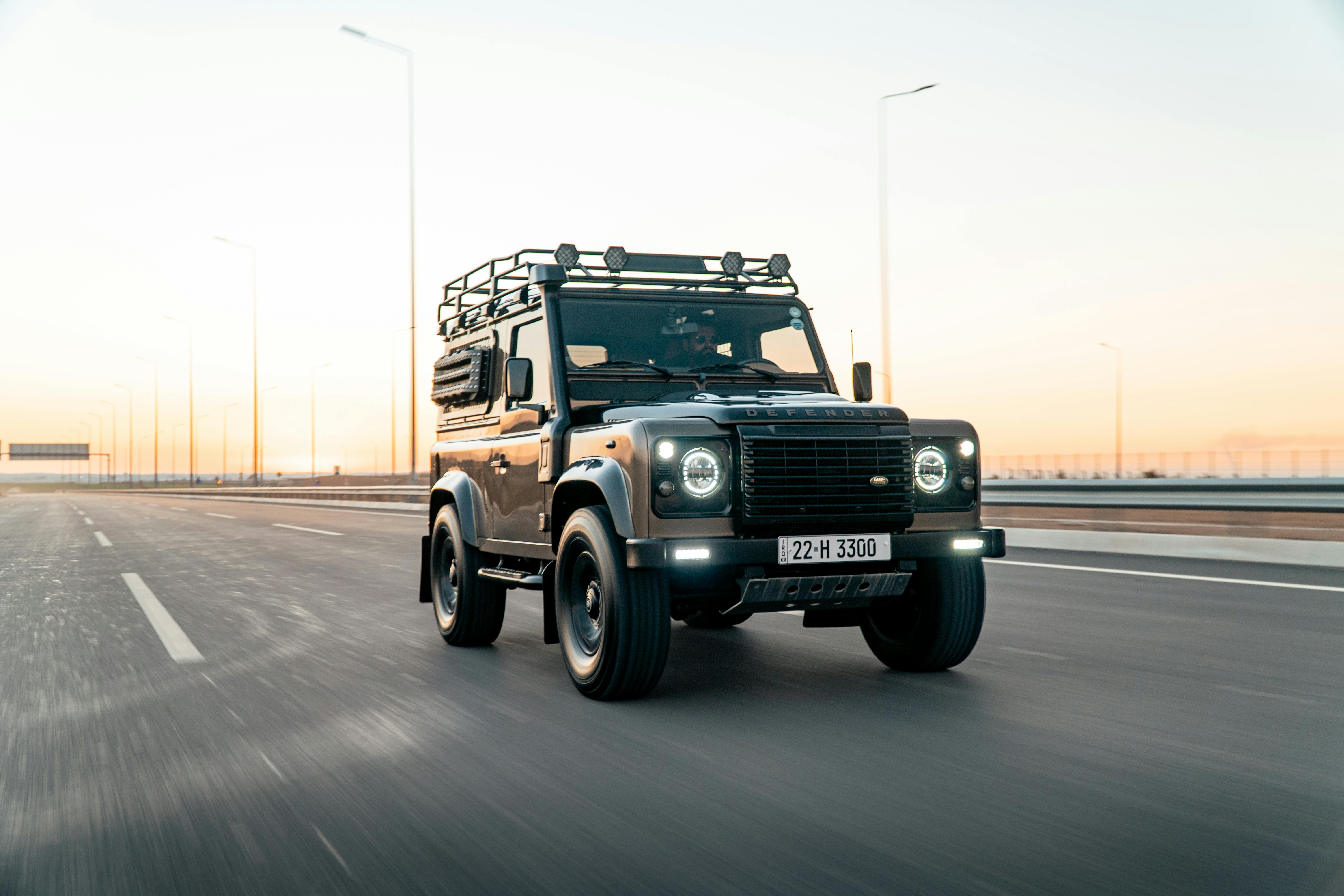 A White Land Rover Defender on Dirt Road · Free Stock Photo