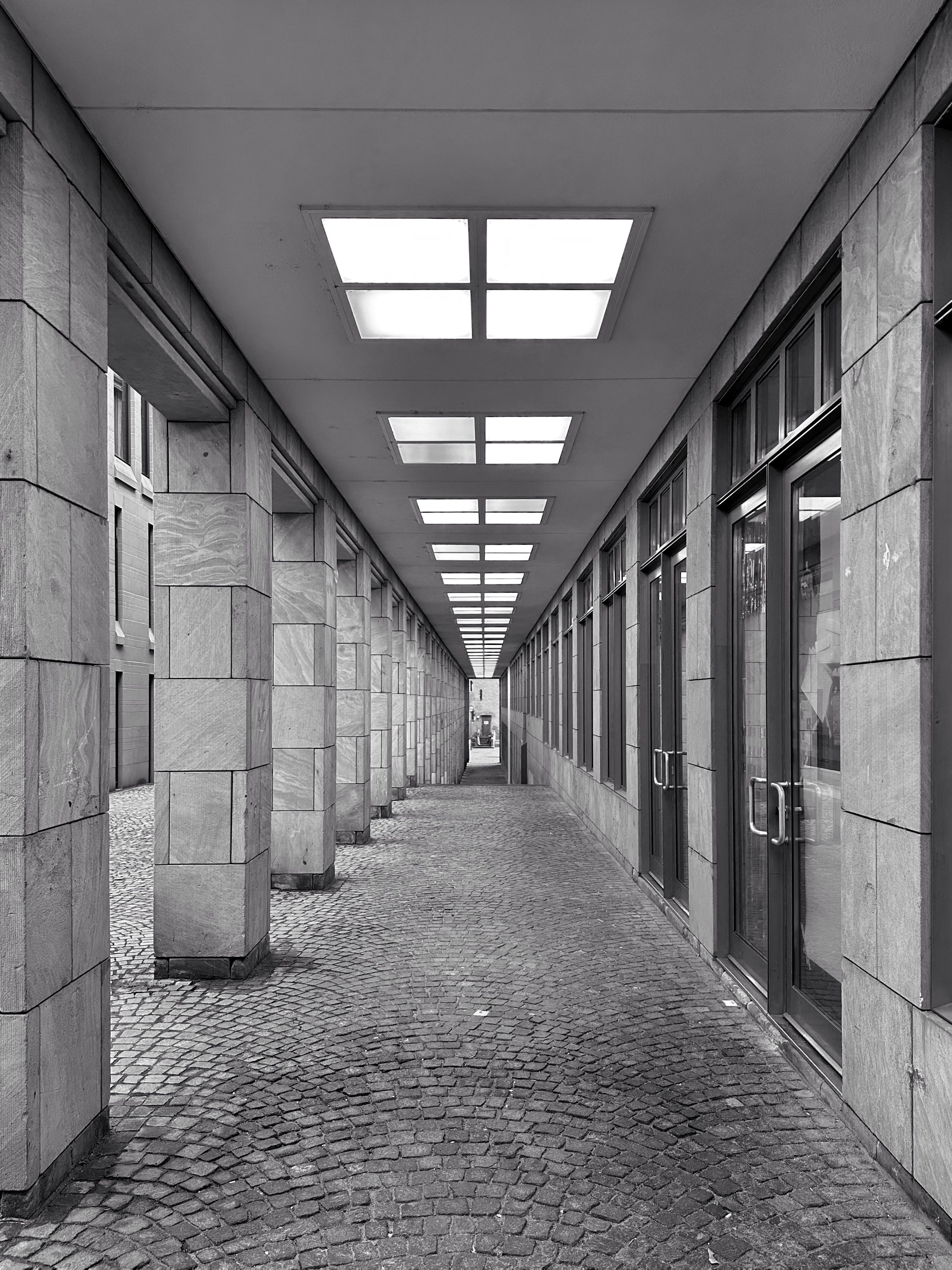 Pillars and Doors Along the Cobbled Passage · Free Stock Photo