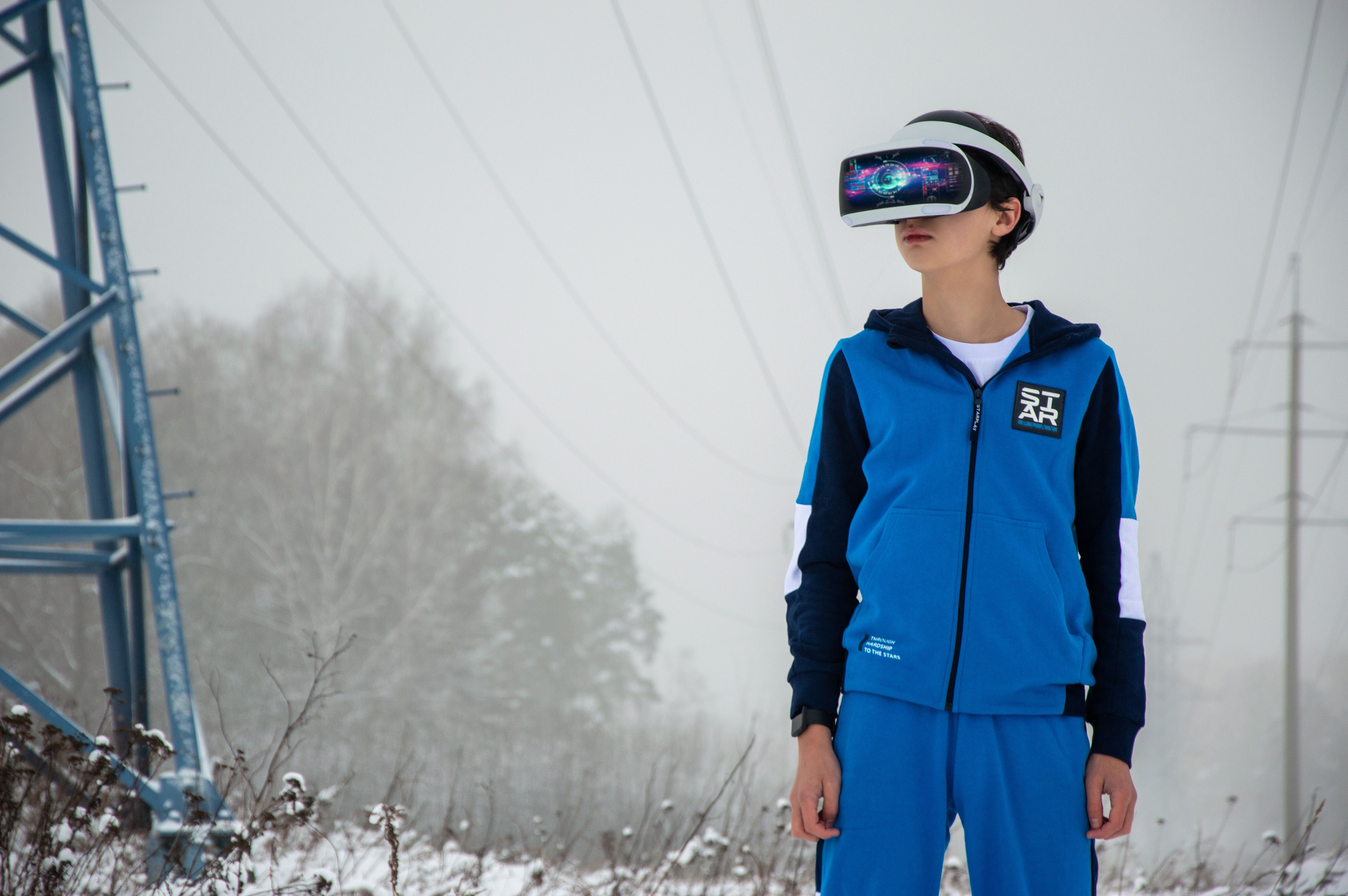 Boy in Blue Tracksuit Standing Outside with VR Goggles · Free Stock Photo