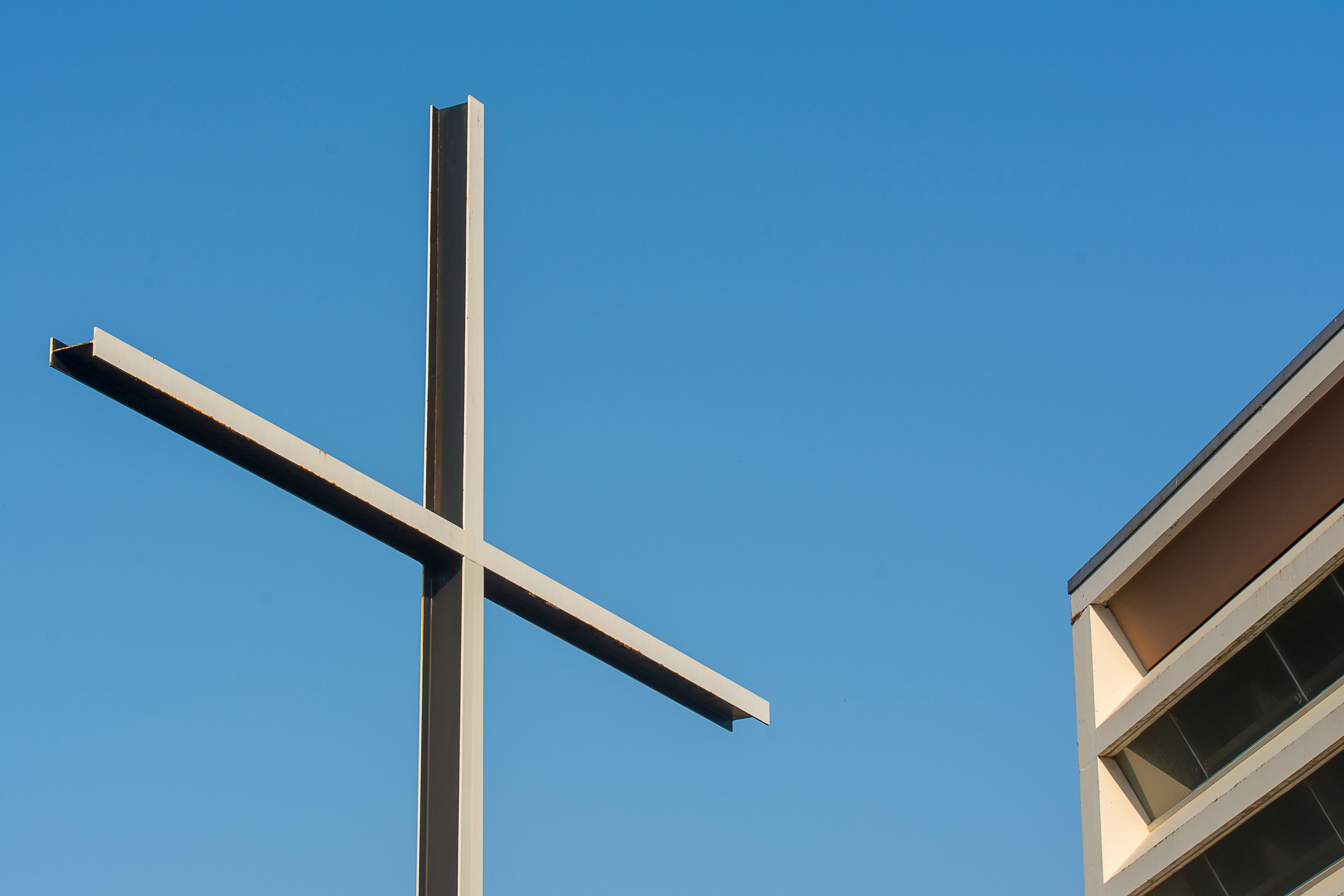 A Cross and Corner of a Building against Blue Sky · Free Stock Photo