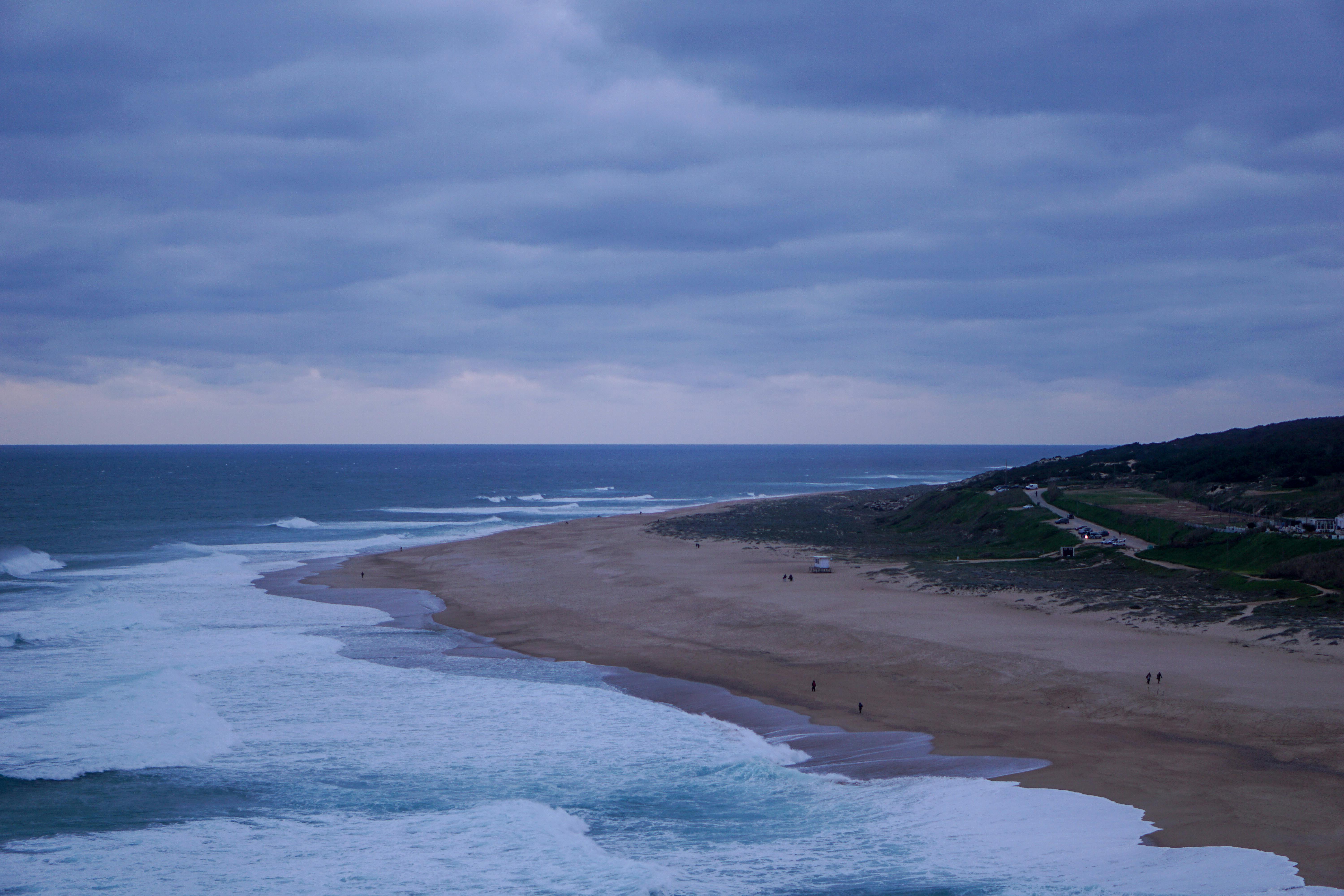 Wide Sandy Beach with Green Hill · Free Stock Photo