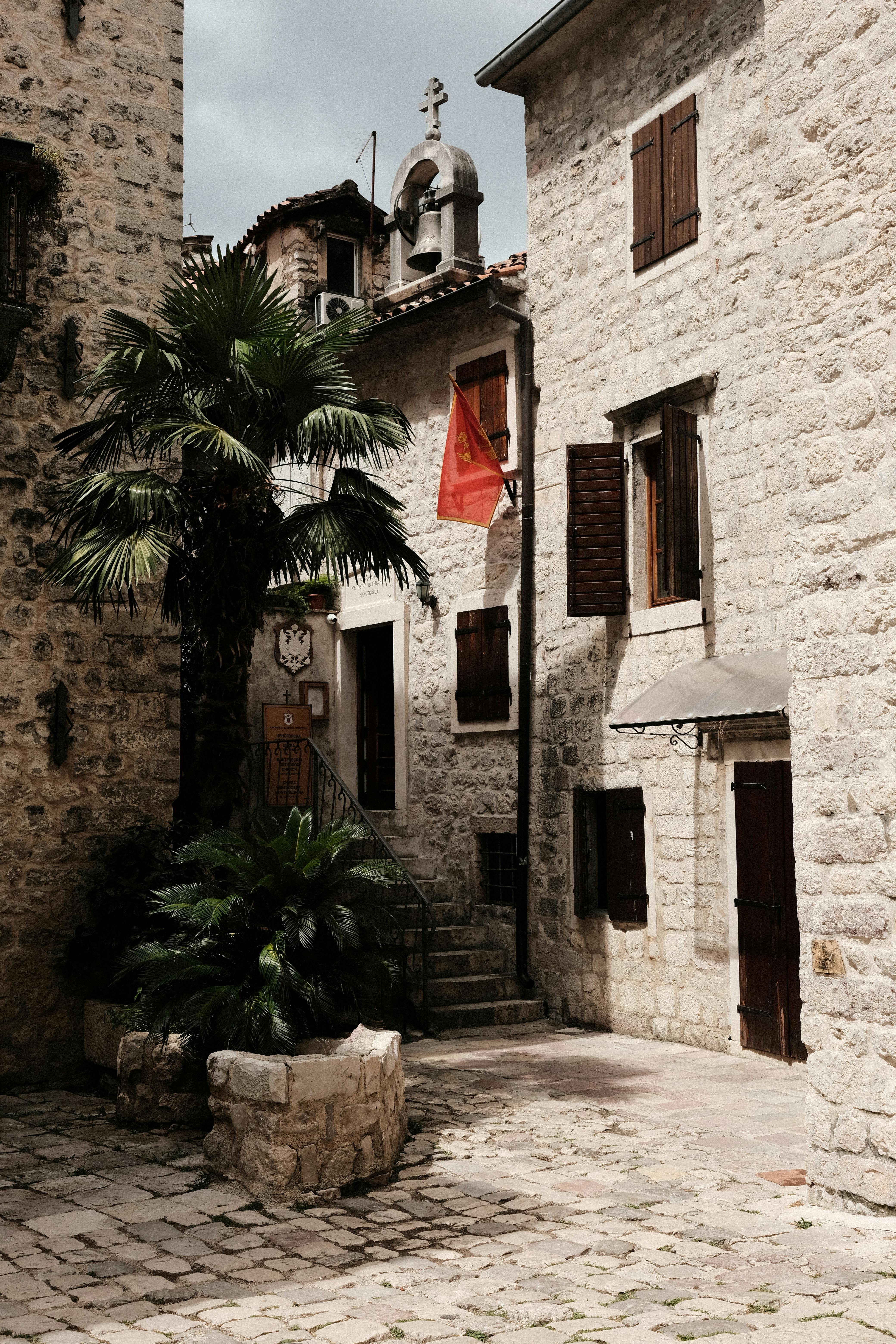 A stone building with a flag in the middle · Free Stock Photo