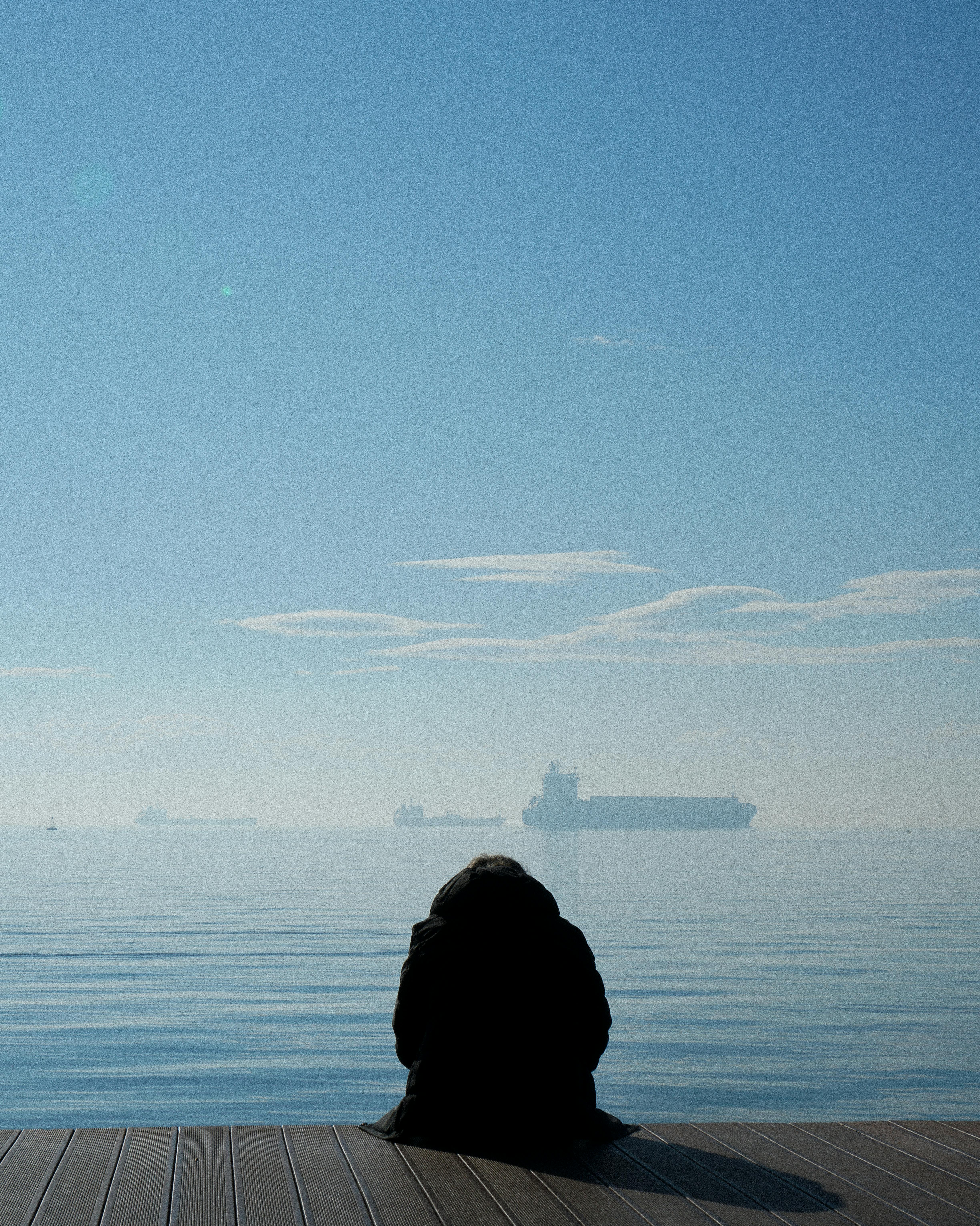a lone soul embraces the serenity of a day at sea · Free Stock Photo