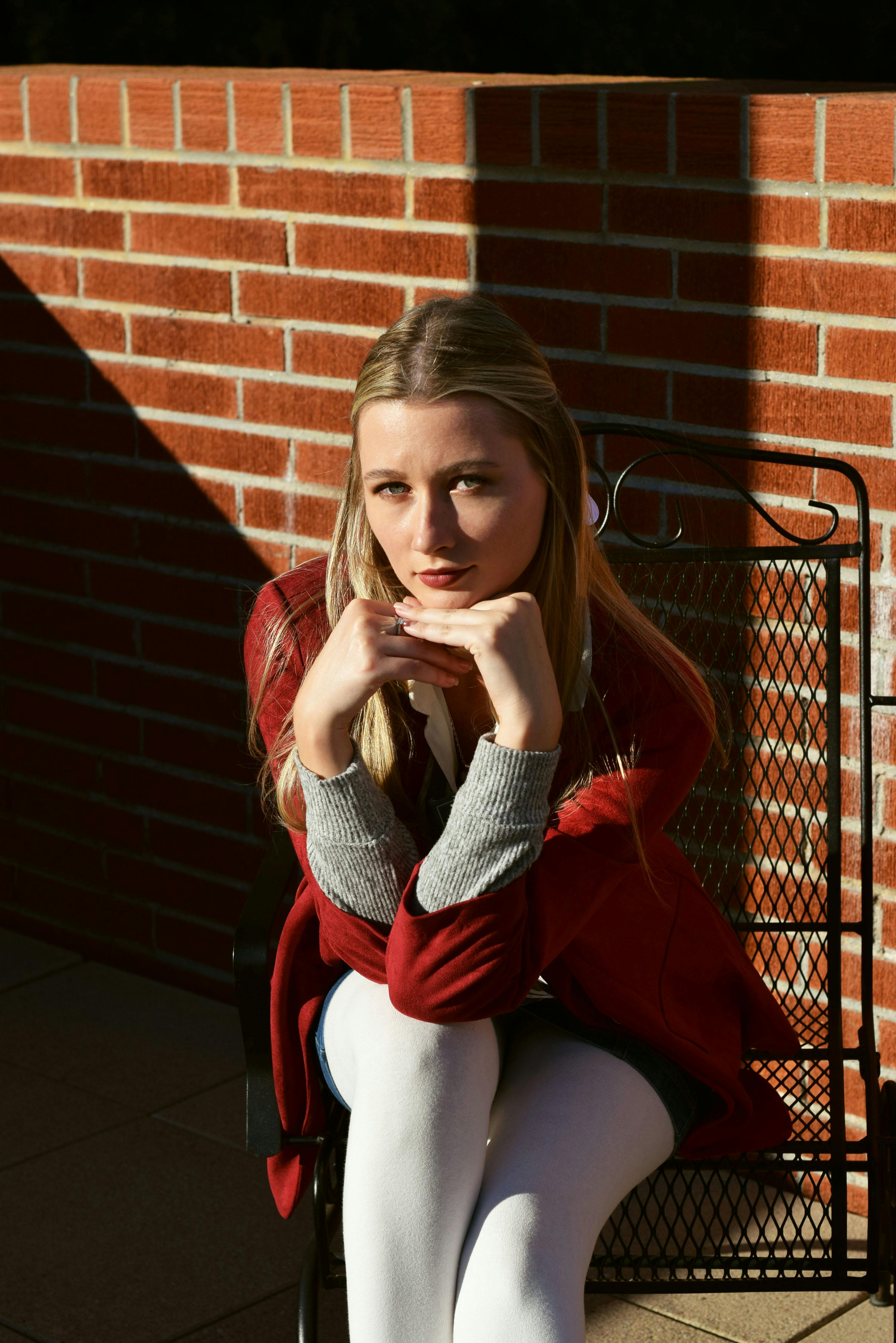 Blonde Woman Sitting by Bricks Wall · Free Stock Photo