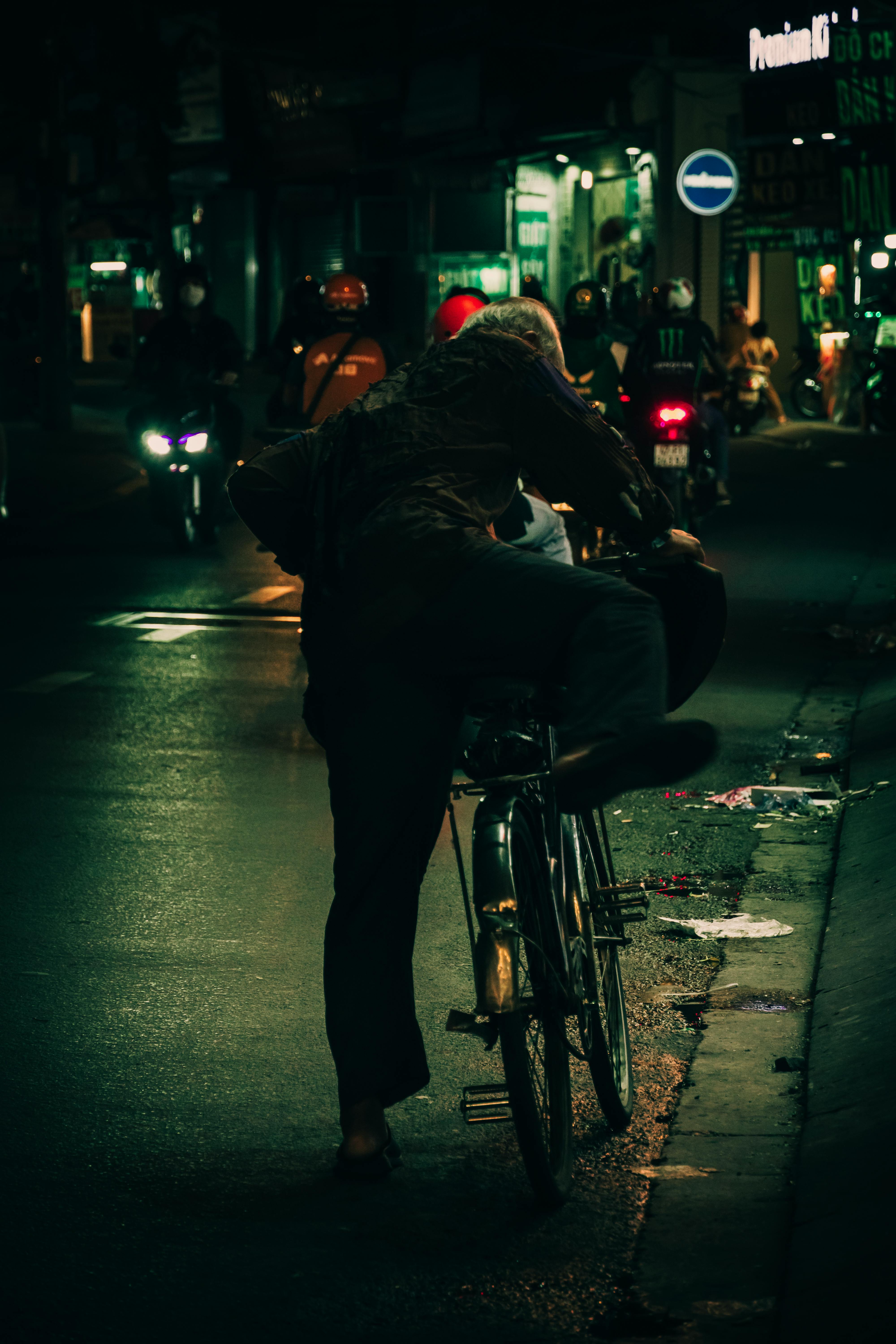 A person riding a bicycle at night · Free Stock Photo