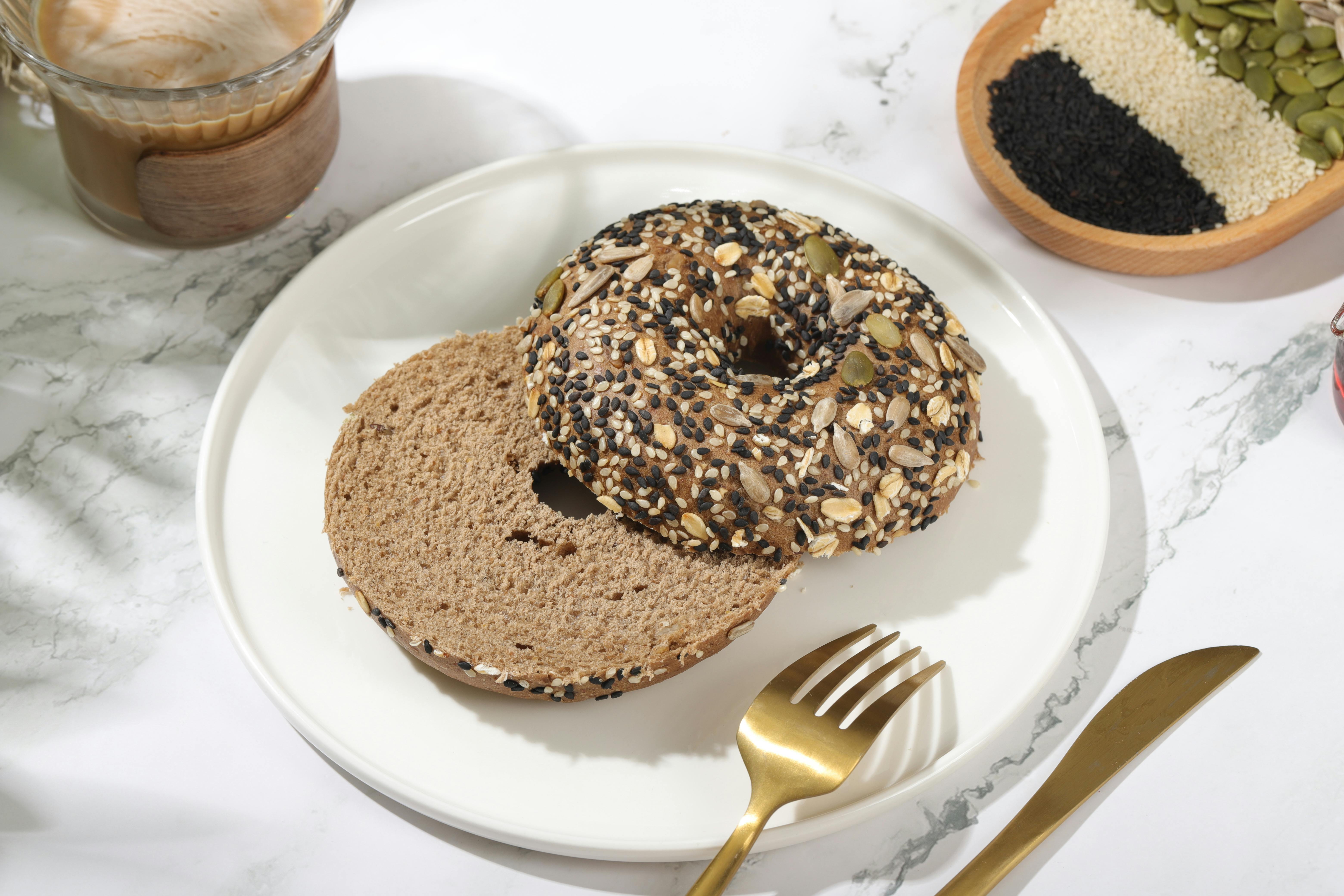 Bagel Cut in Half on White Plate · Free Stock Photo