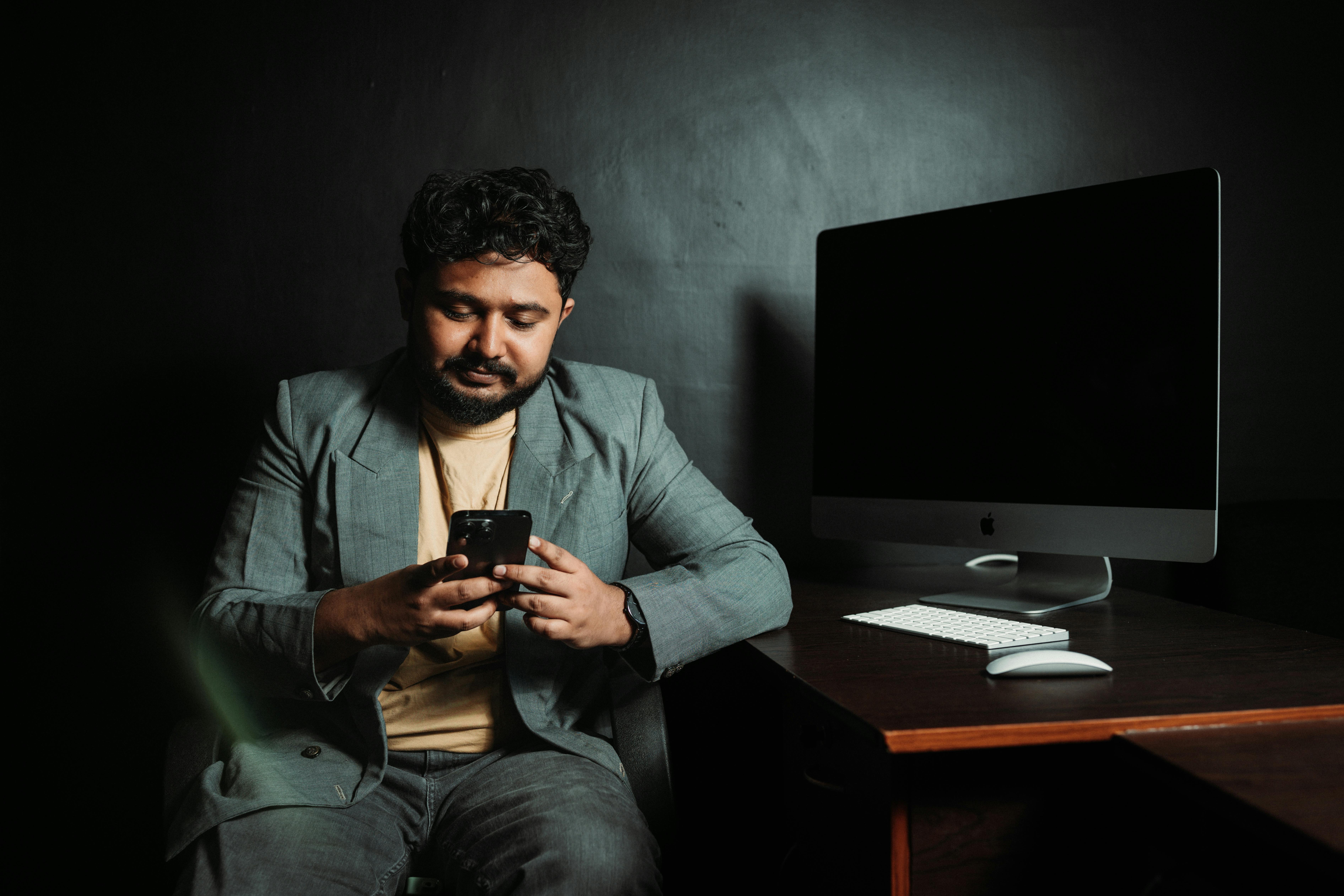Man Using Computer Sitting on Chair · Free Stock Photo