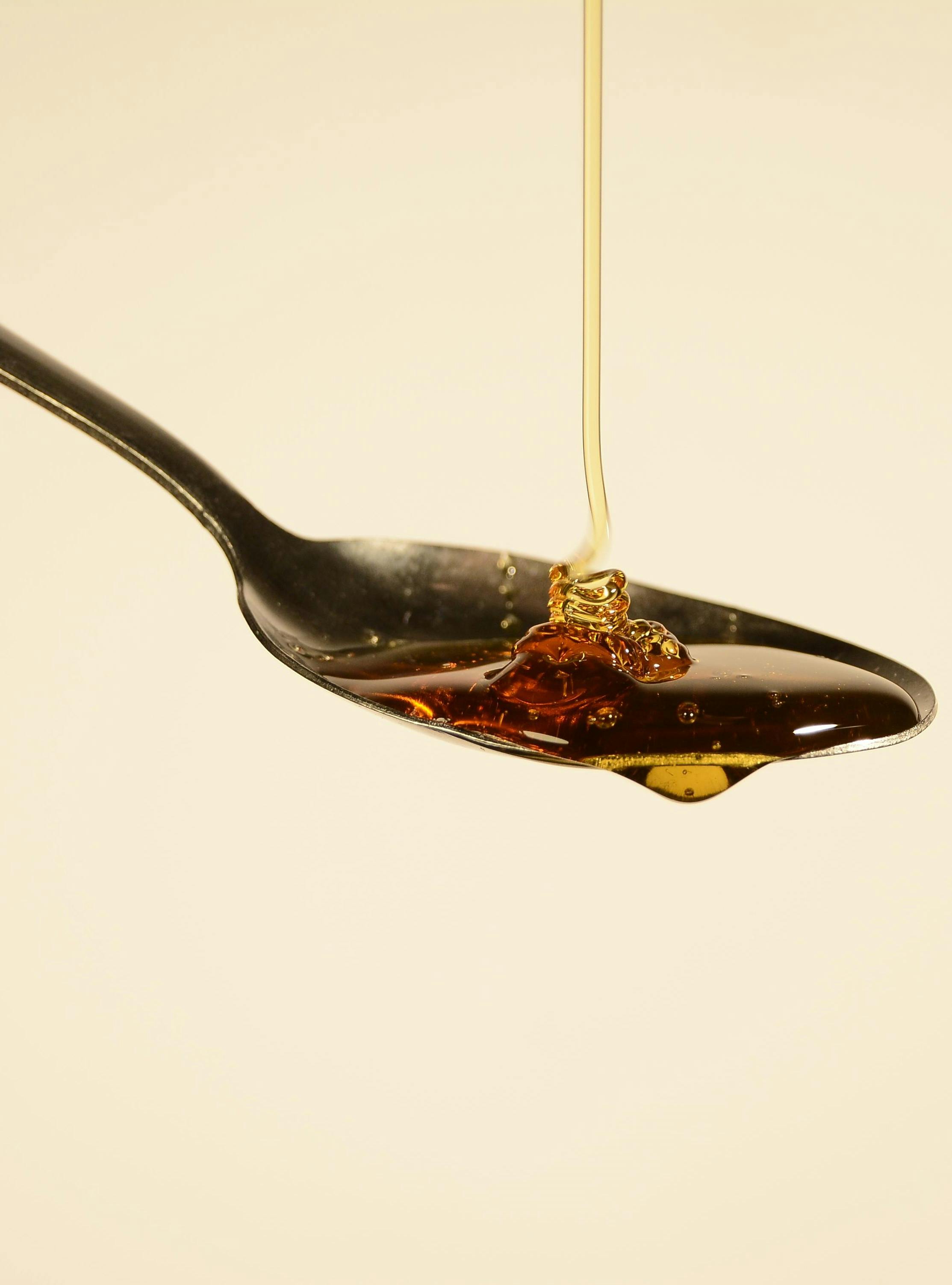 Golden Syrup Dripping from Spoon Close-Up · Free Stock Photo