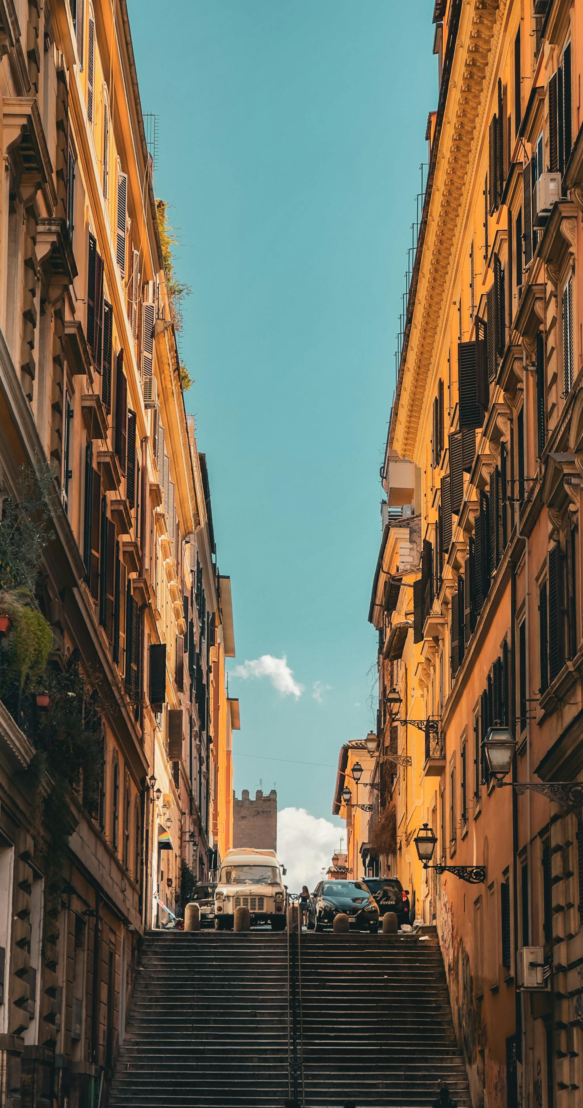 A narrow street with buildings and cars · Free Stock Photo